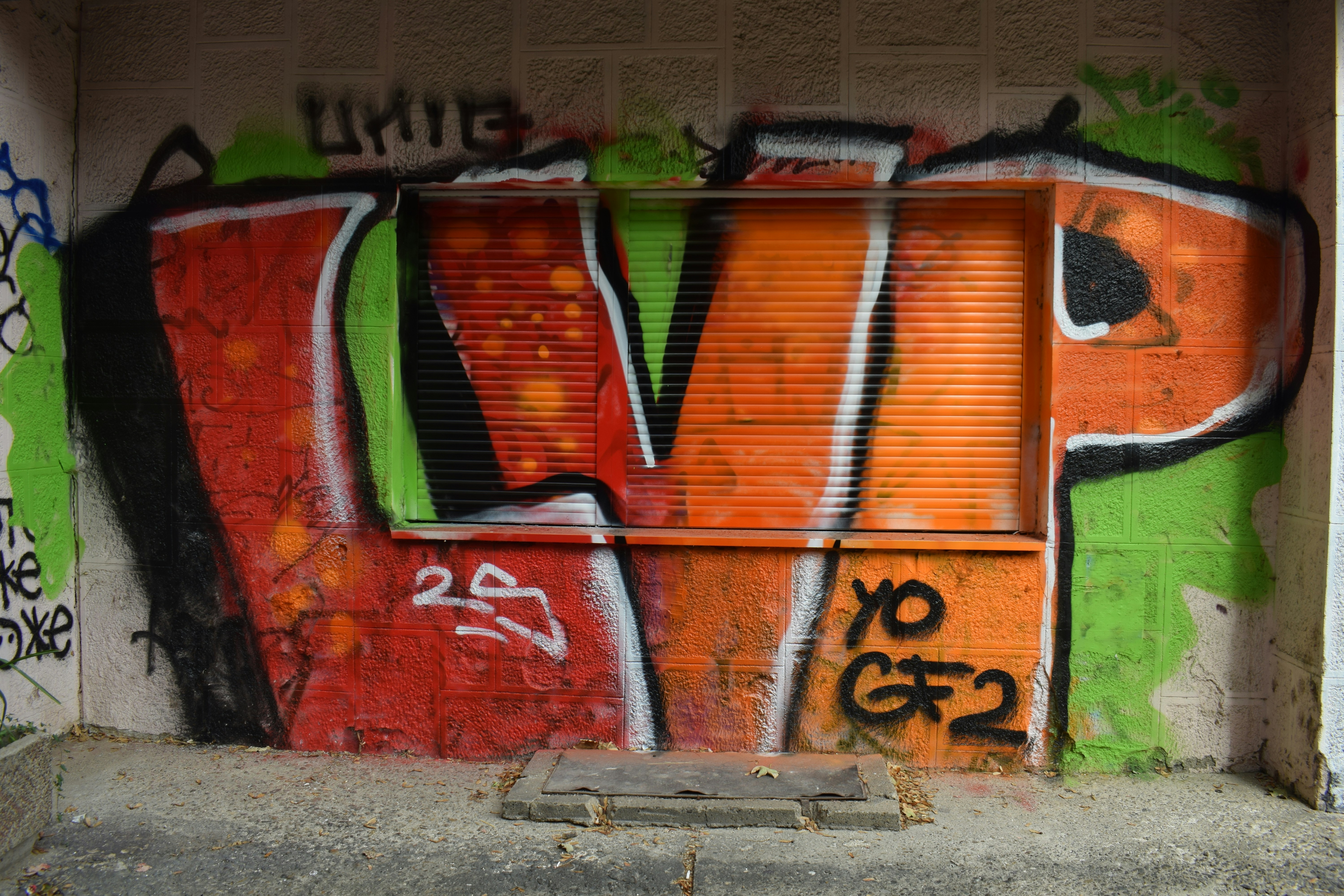 Graffiti art with orange, green, and black spray paint.