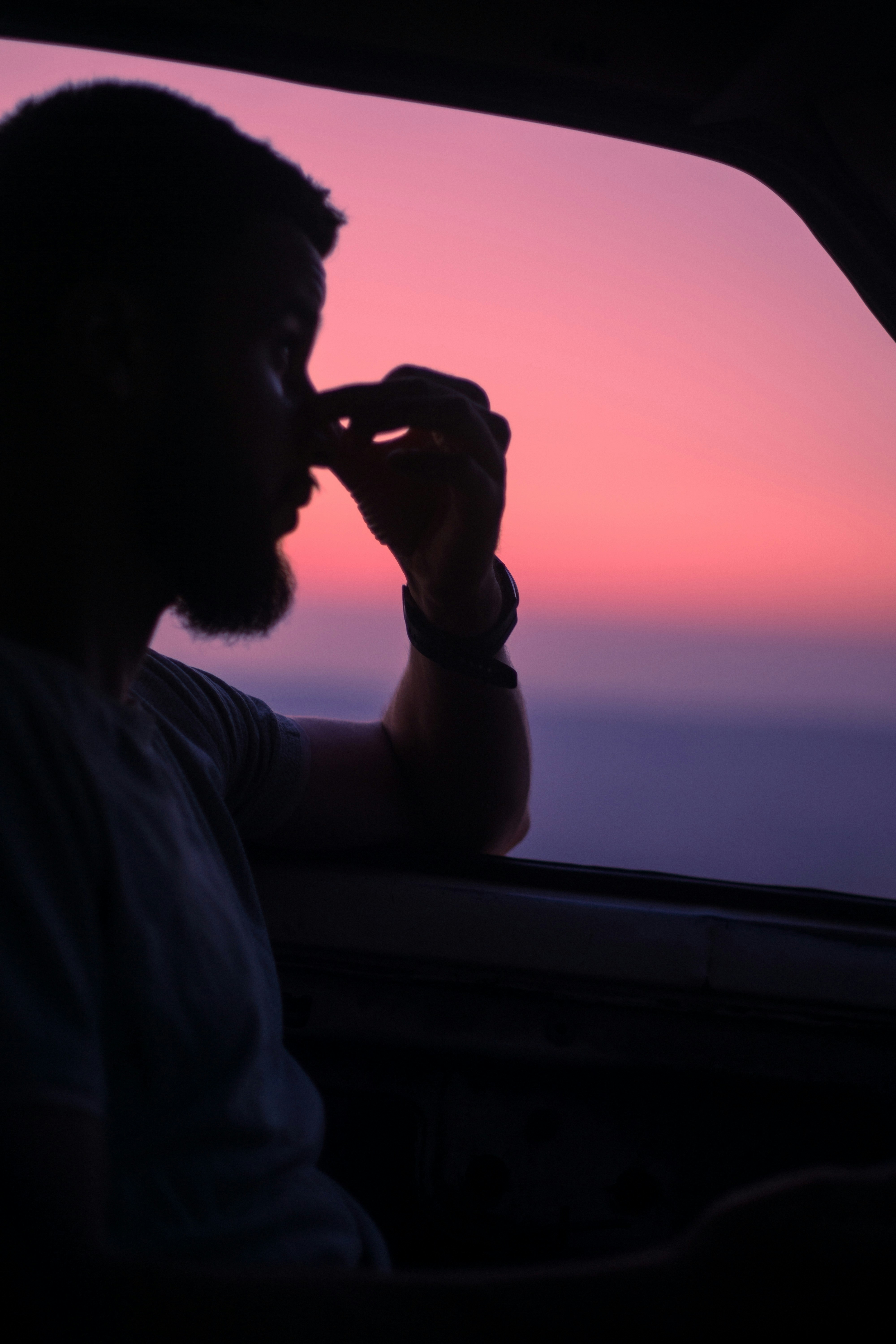 Quiet Sunset Silhouette: A Contemplative Moment Behind the Car Window
