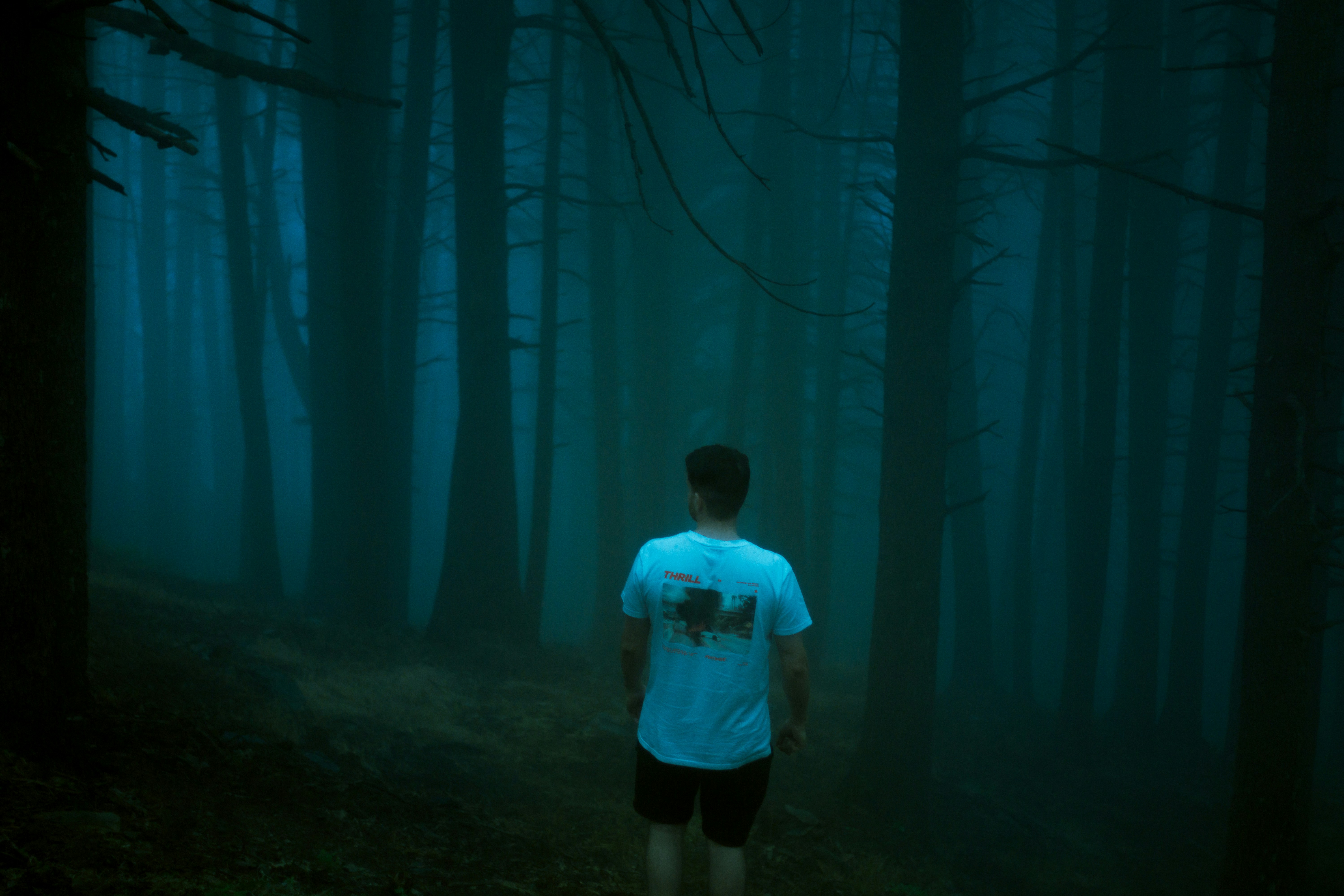 Man walking through a foggy, dark forest