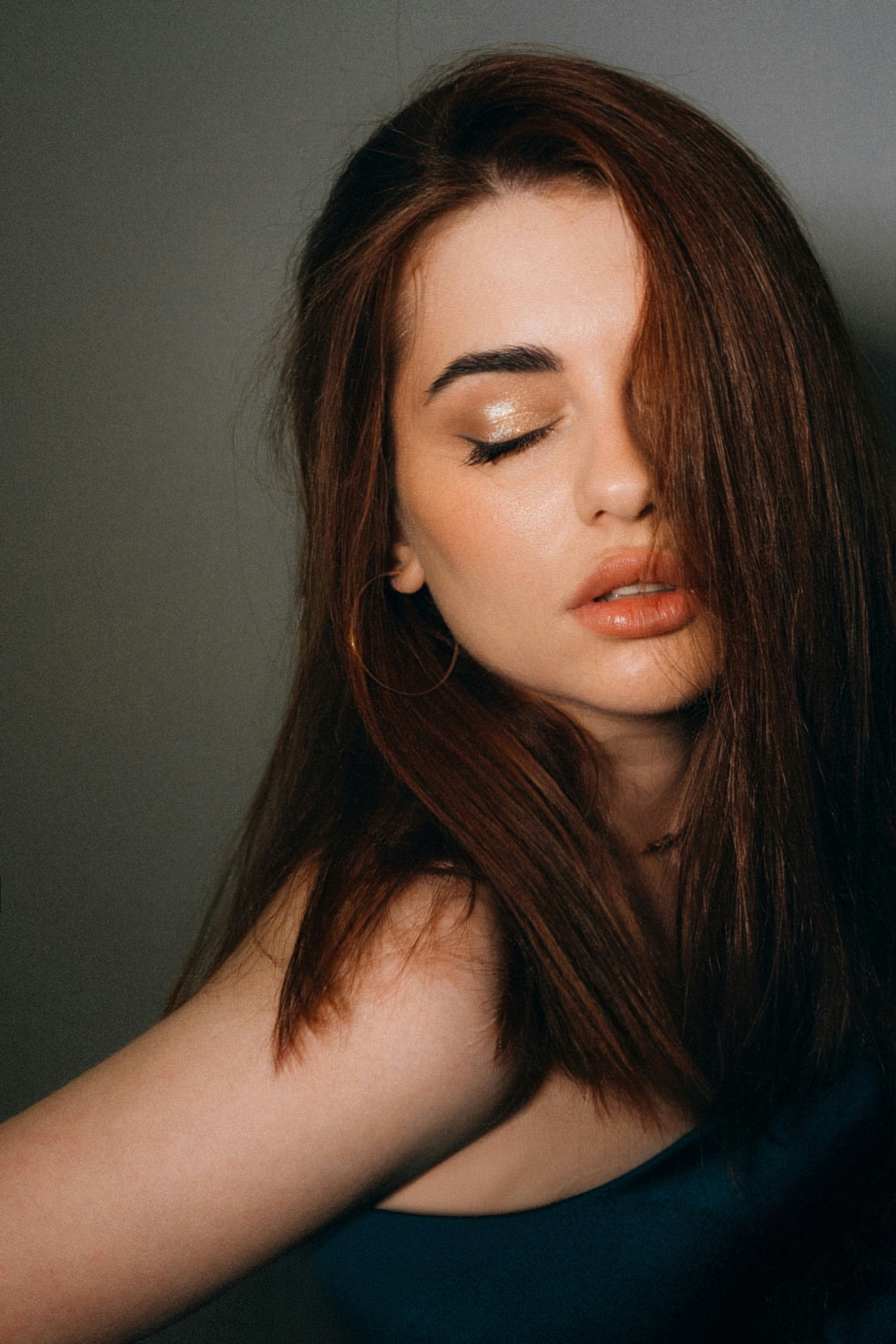 A young woman with auburn hair and closed eyes.