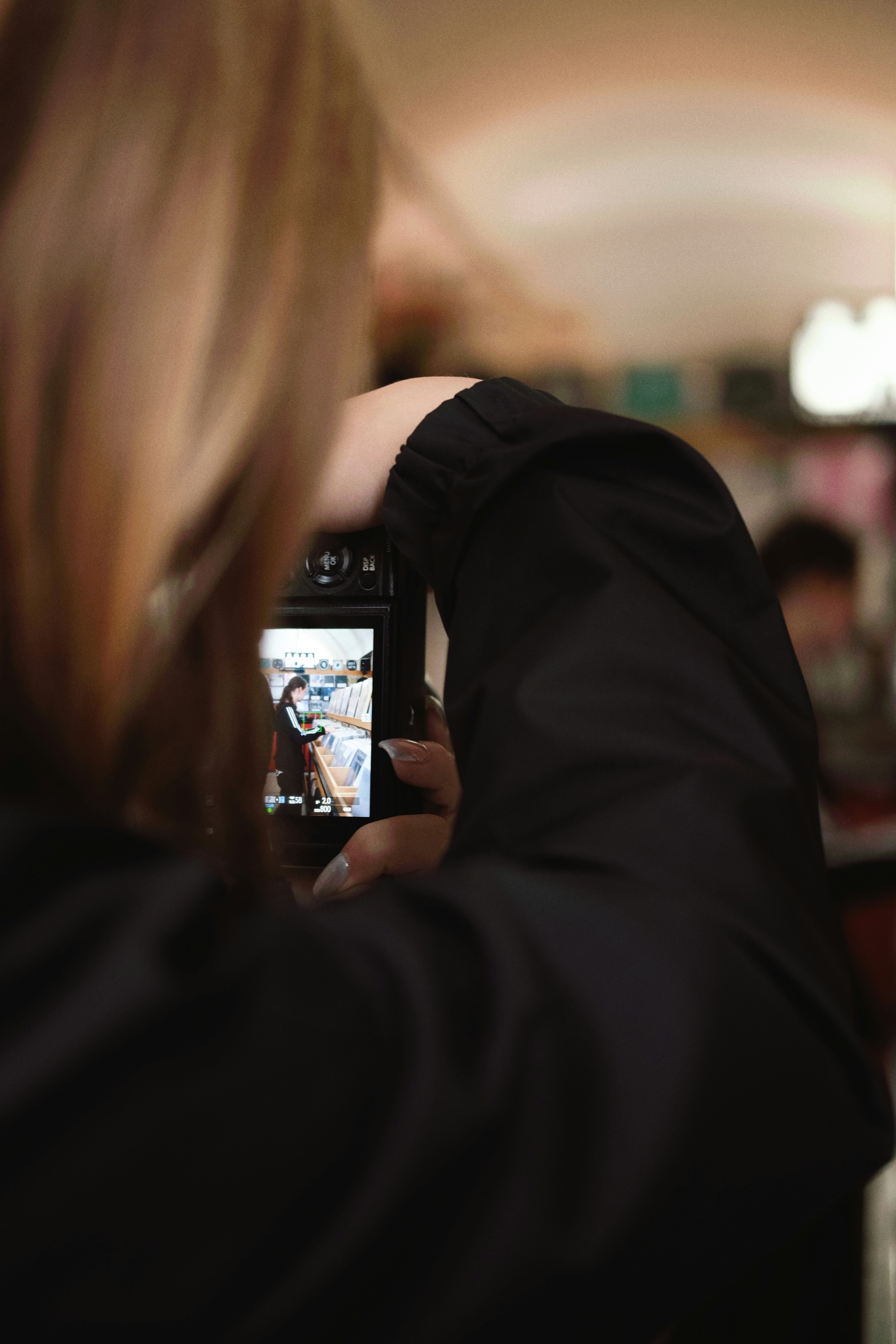 A photographer captures a moment on their Fujifilm X-T2, showcasing the interaction between the subject and the camera's display.