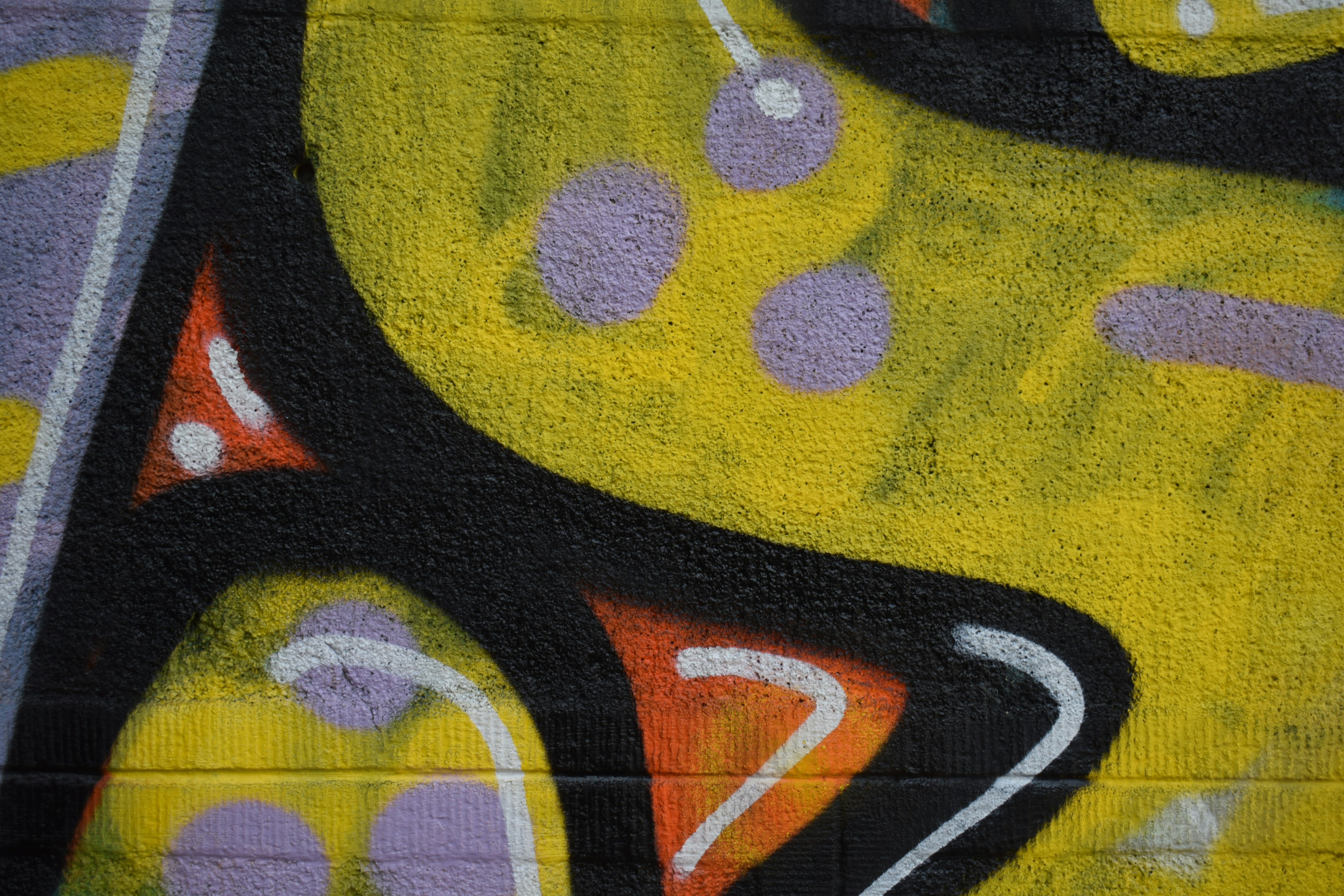 Abstract graffiti art with yellow, black, and purple elements.