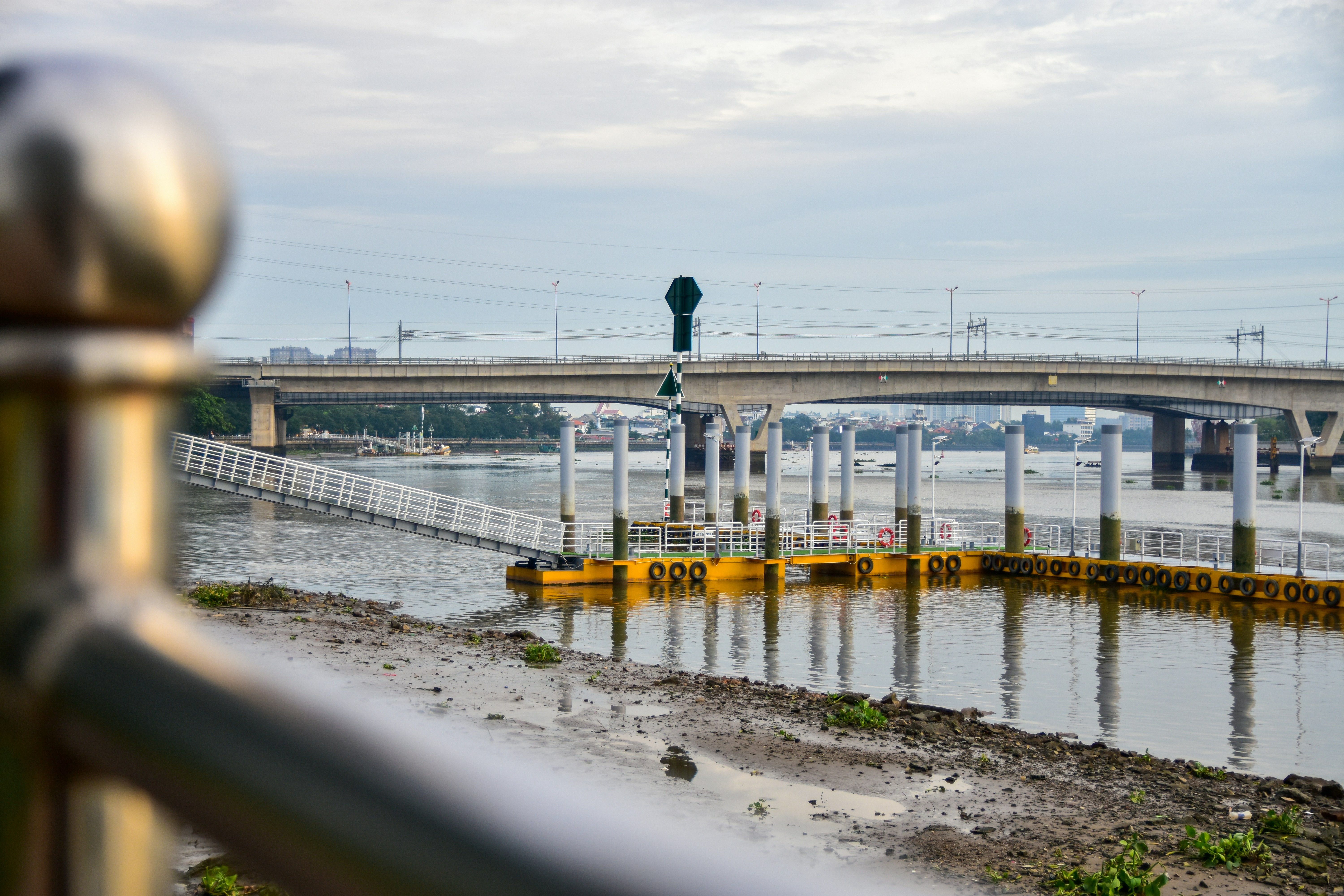 Floating dock with bridge in background over water photo – Free River ...