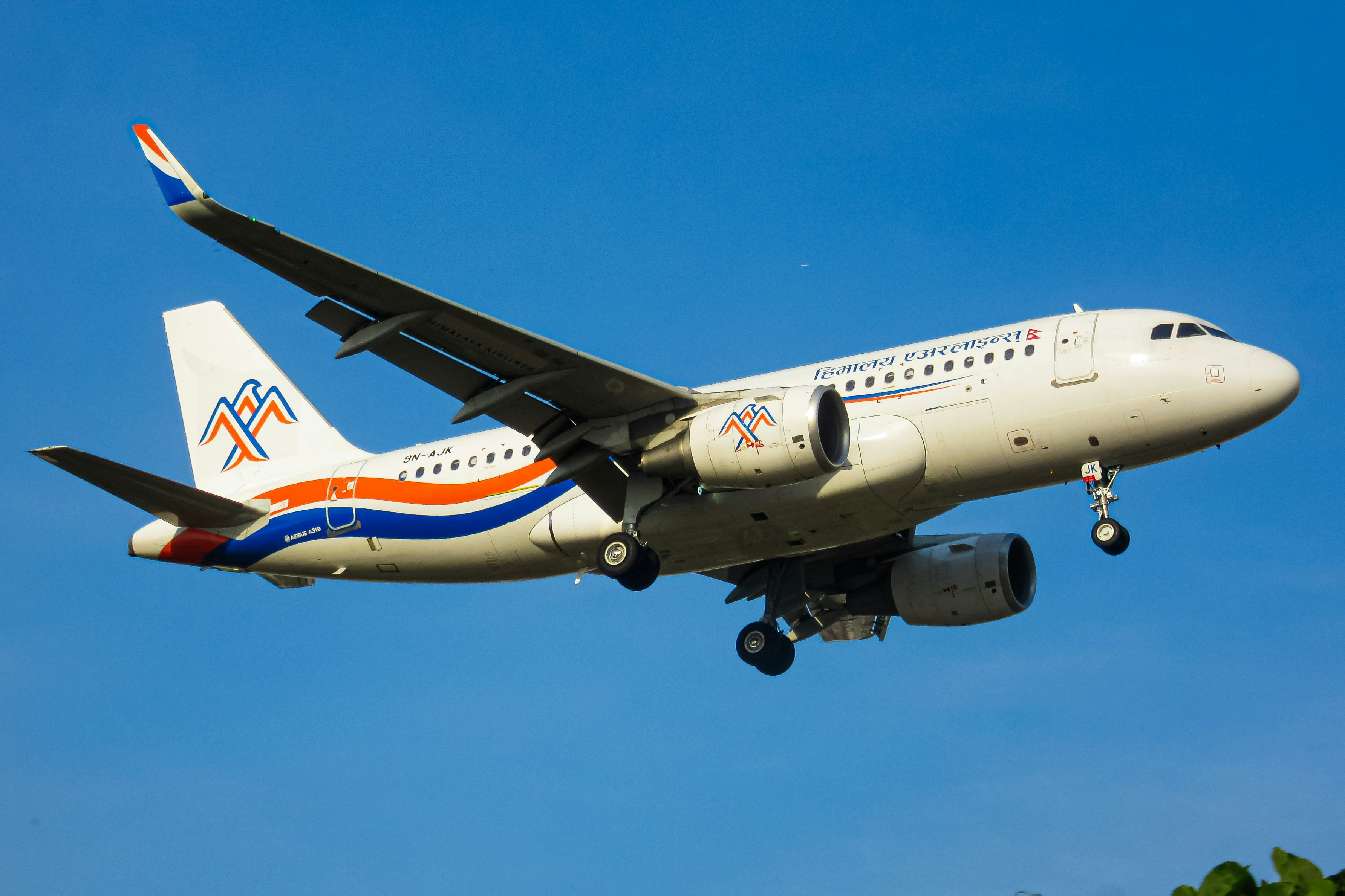 A commercial airplane flying against a clear blue sky.
