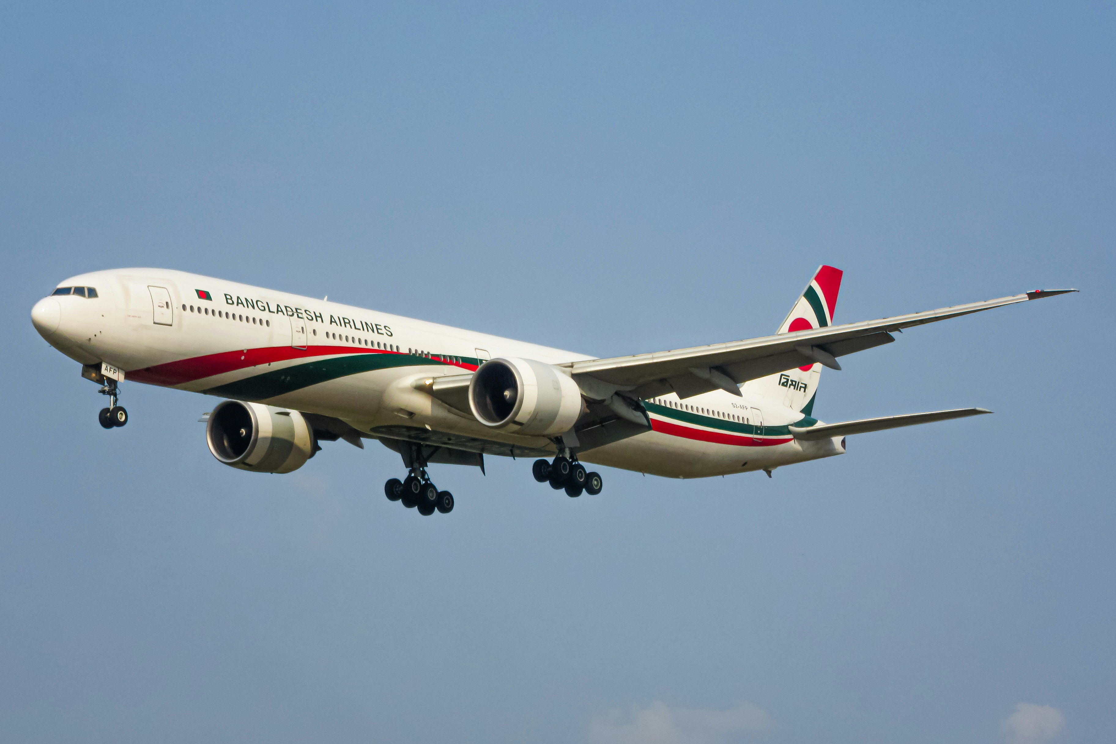 Bangladesh Airlines aircraft approaching for landing against a clear blue sky.