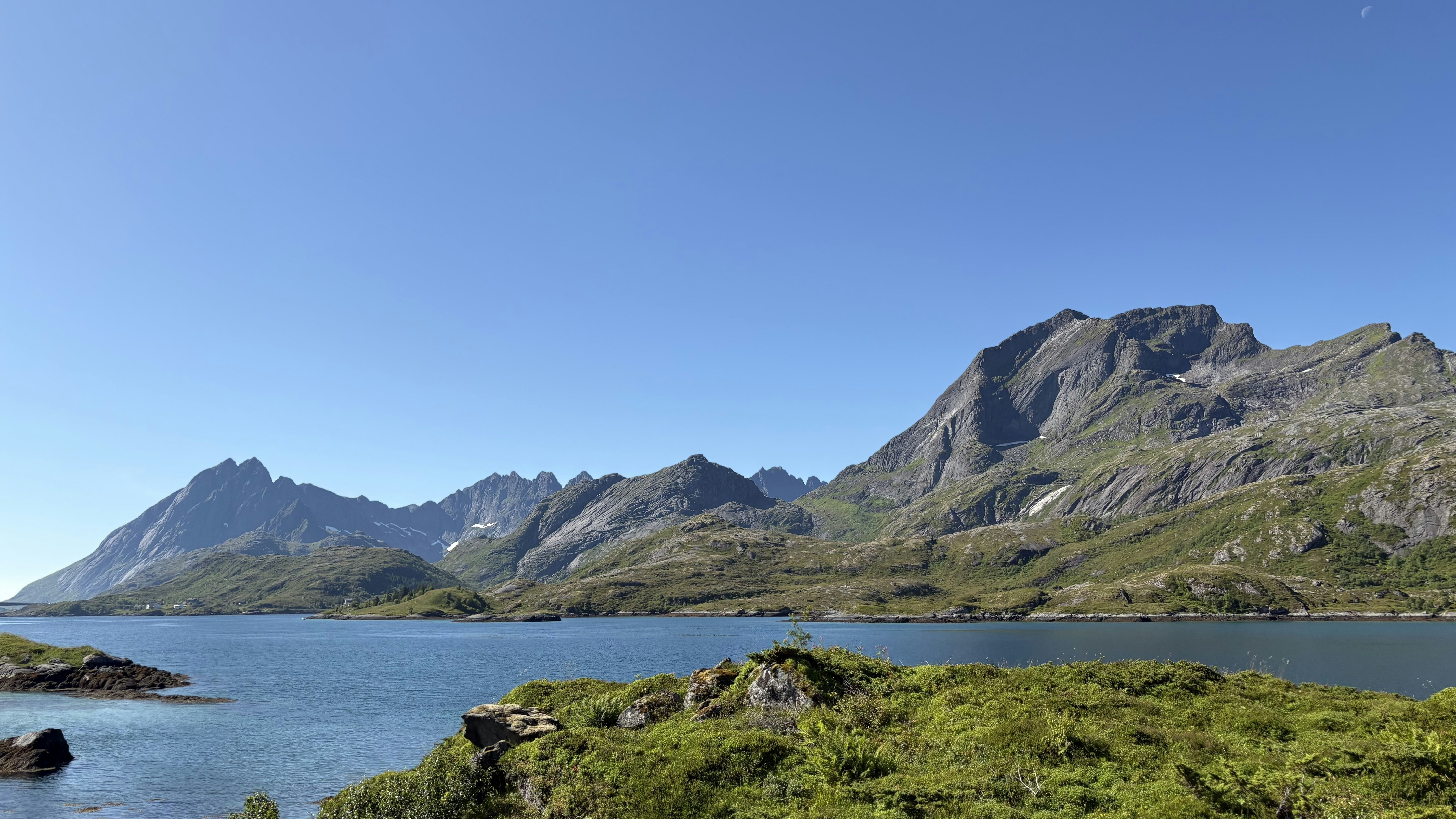 Jagged mountains rise above a calm blue lake