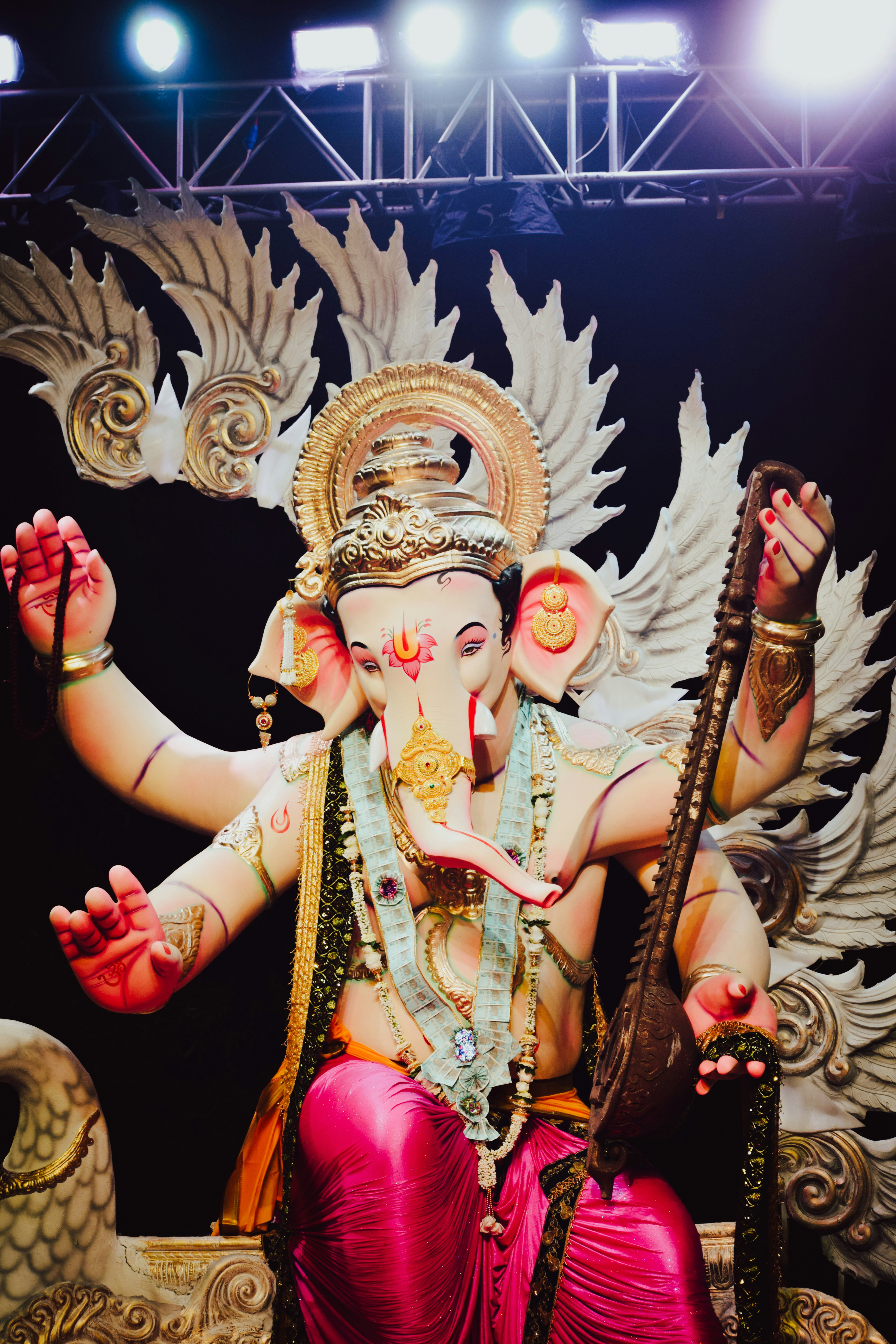 A statue of lord ganesha holding a musical instrument.