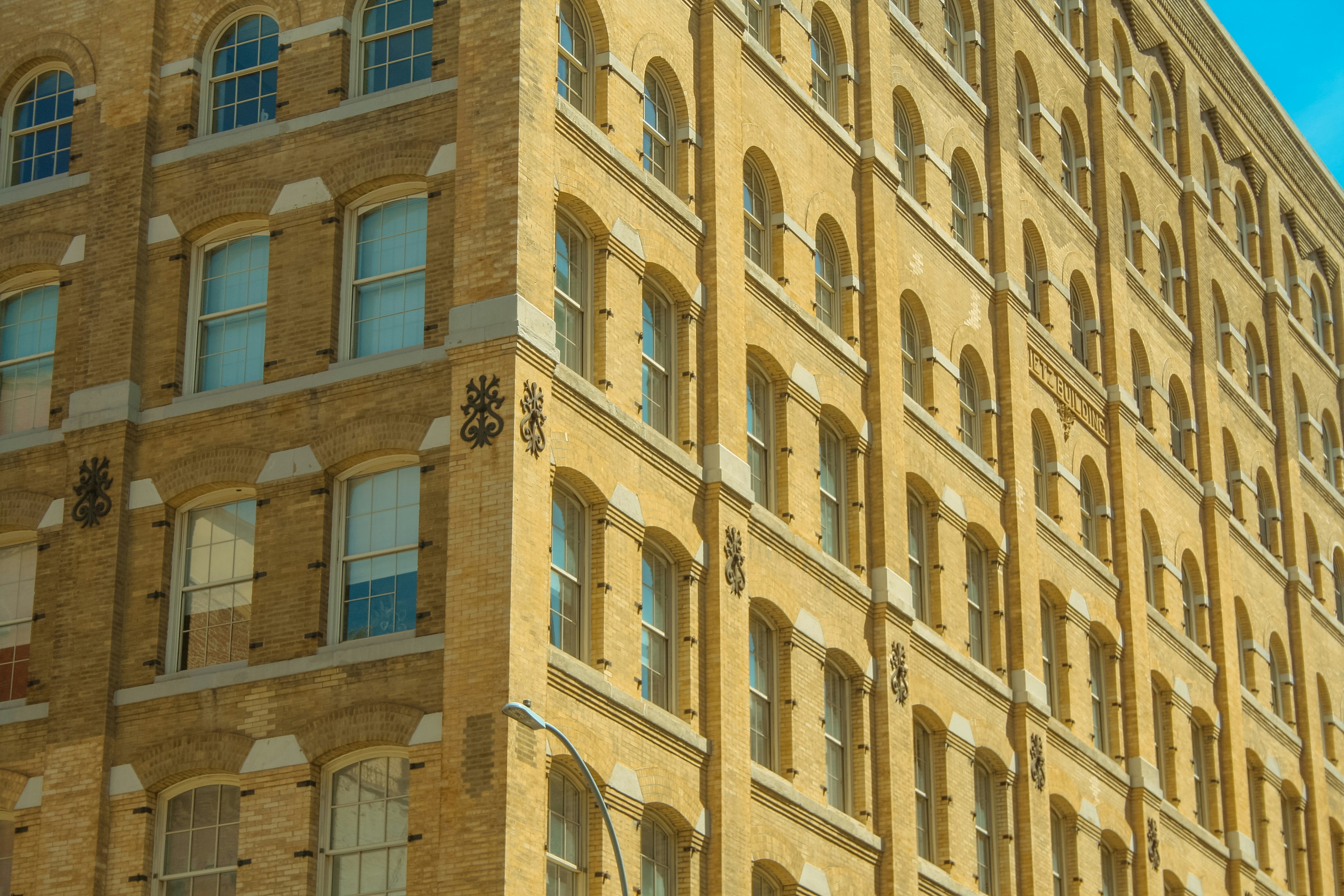 Detailed view of a vintage brick building showcasing its ornate windows and architectural features.