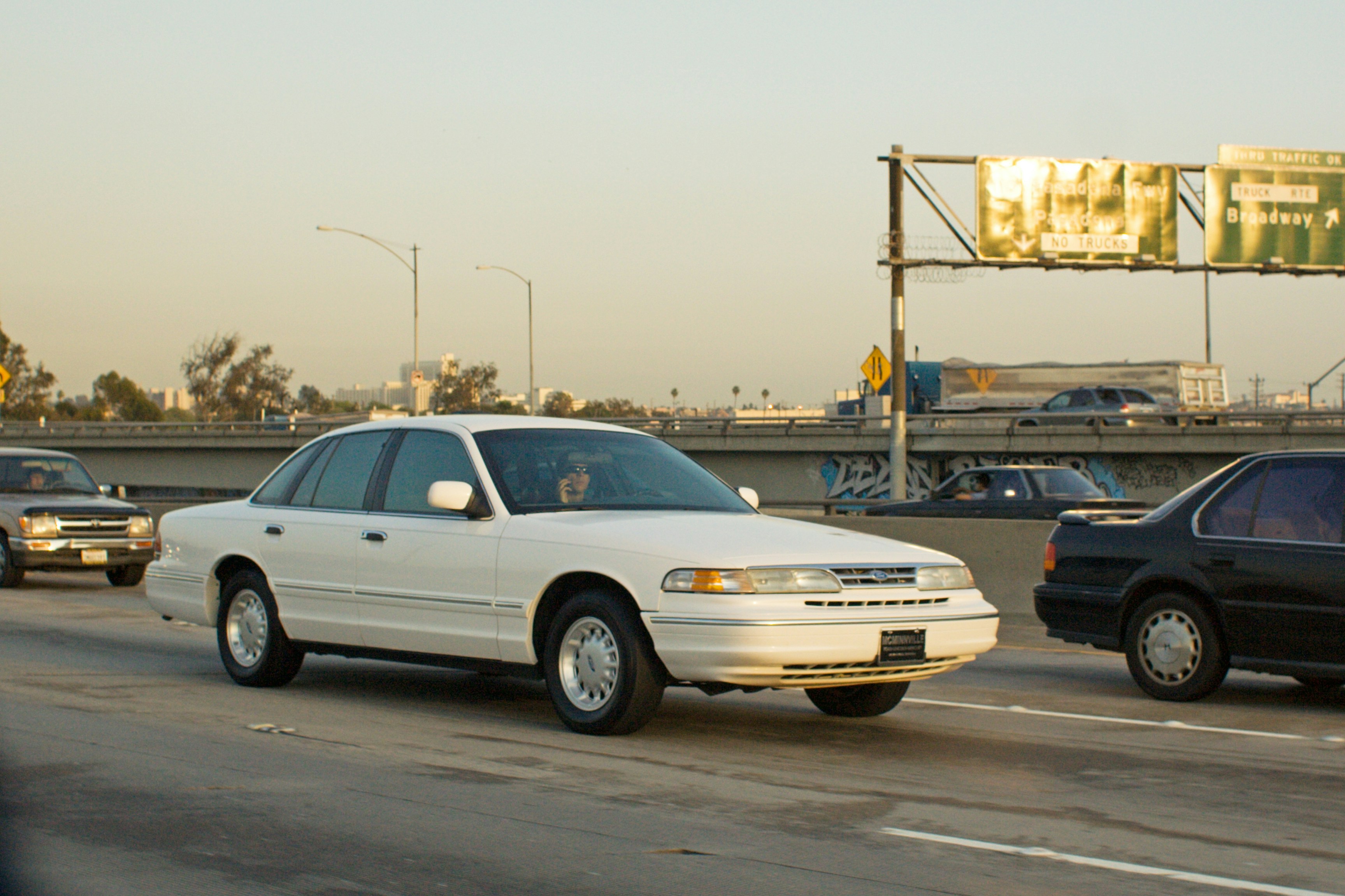 White Sedan on a Sunlit Freeway: A Moment in Everyday Traffic