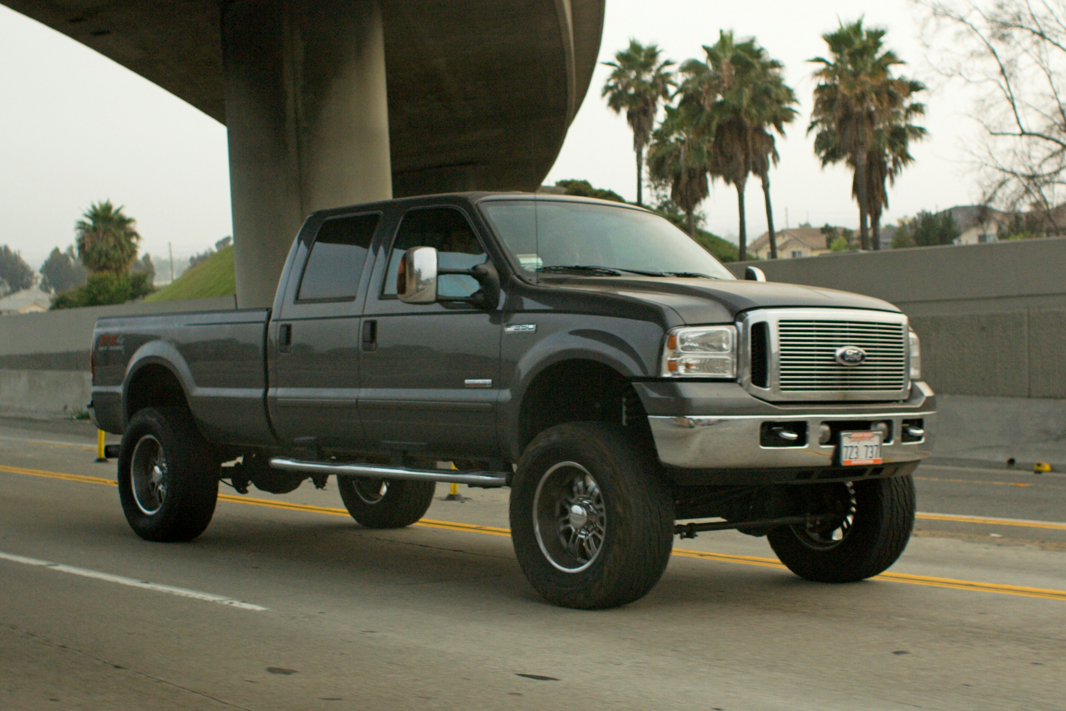 A dark gray pickup truck driving on a highway.