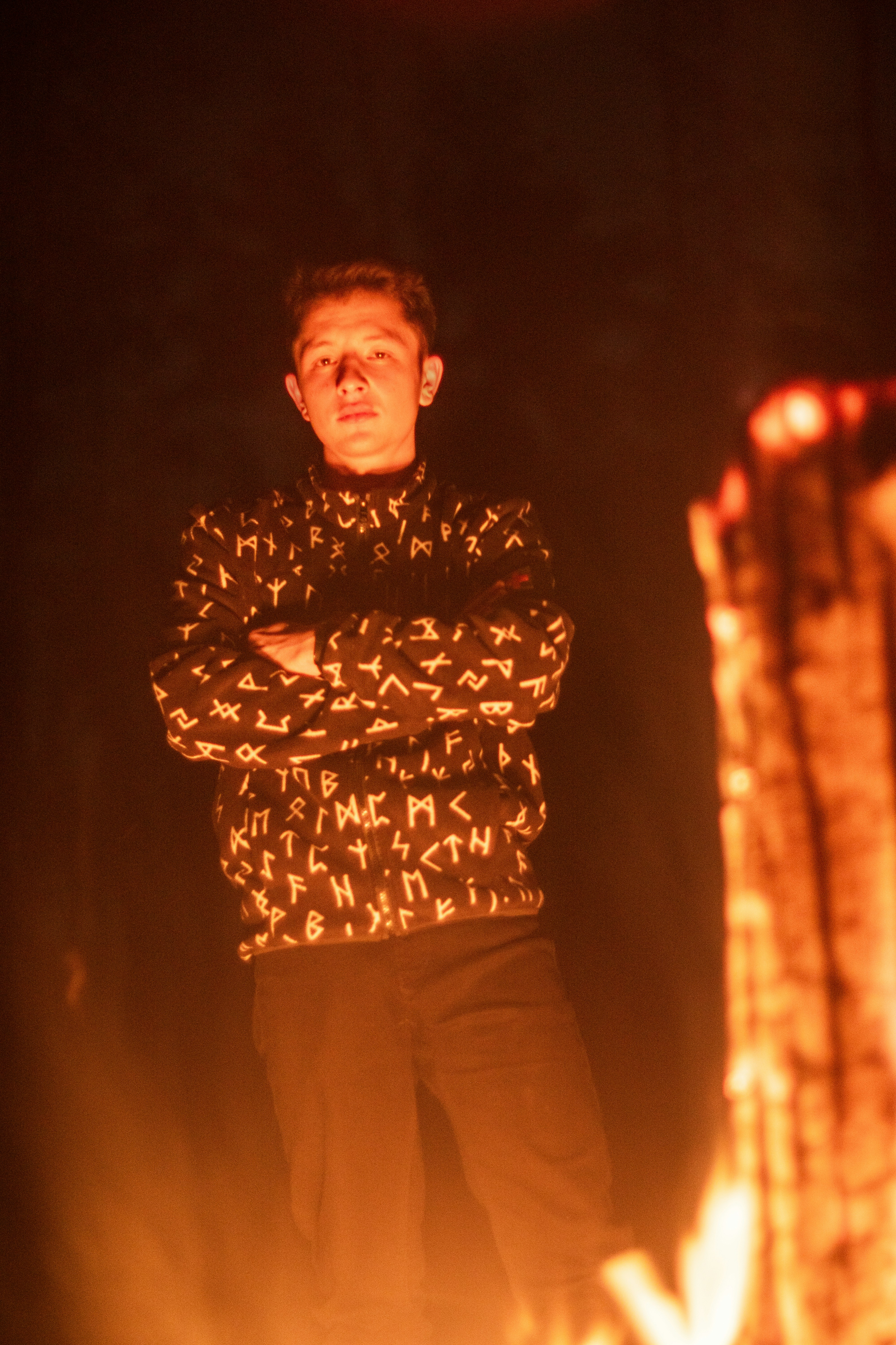 Young man standing in front of a bonfire
