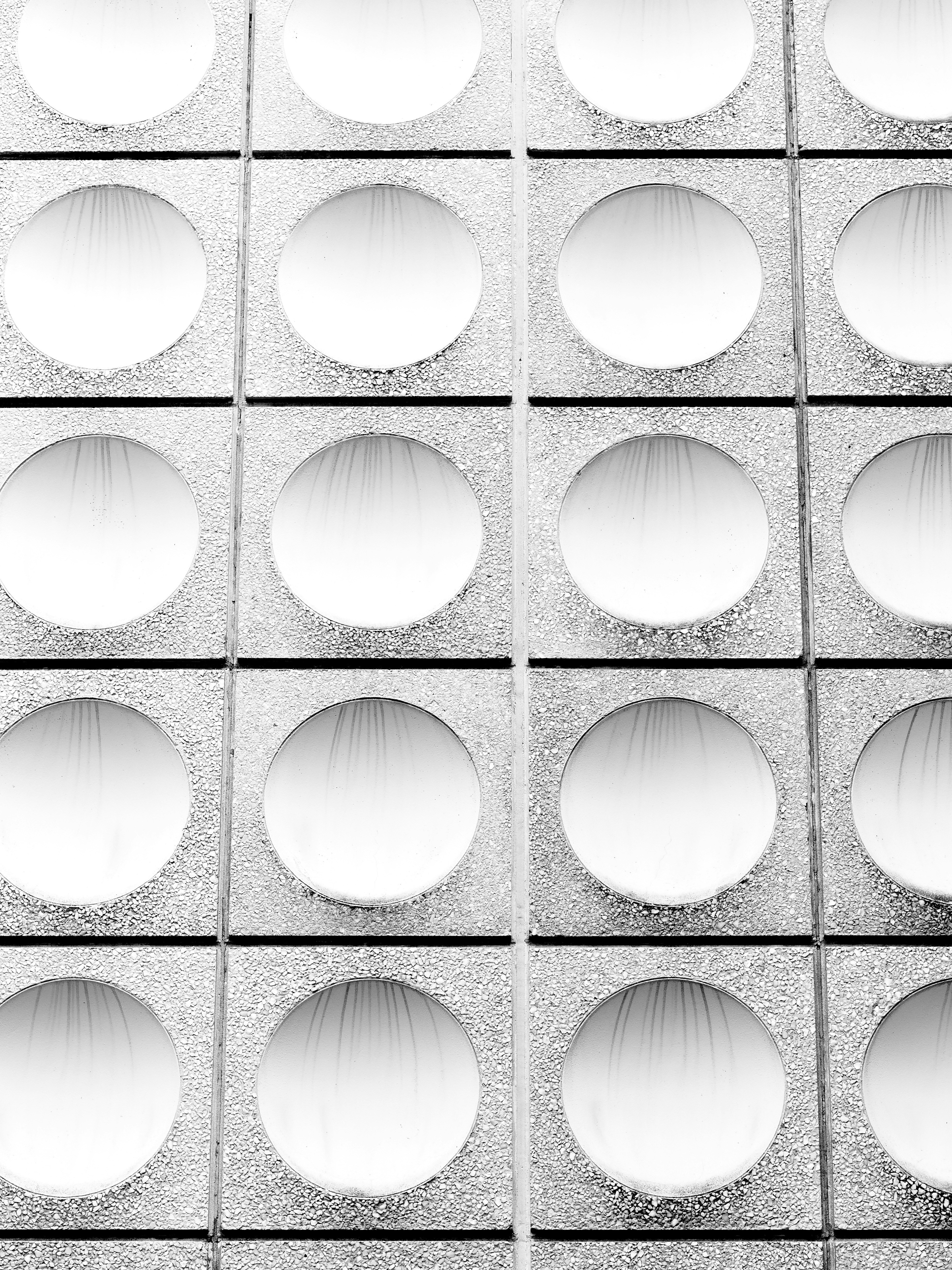 Modern building facade | Grid of circular indentations in a textured wall