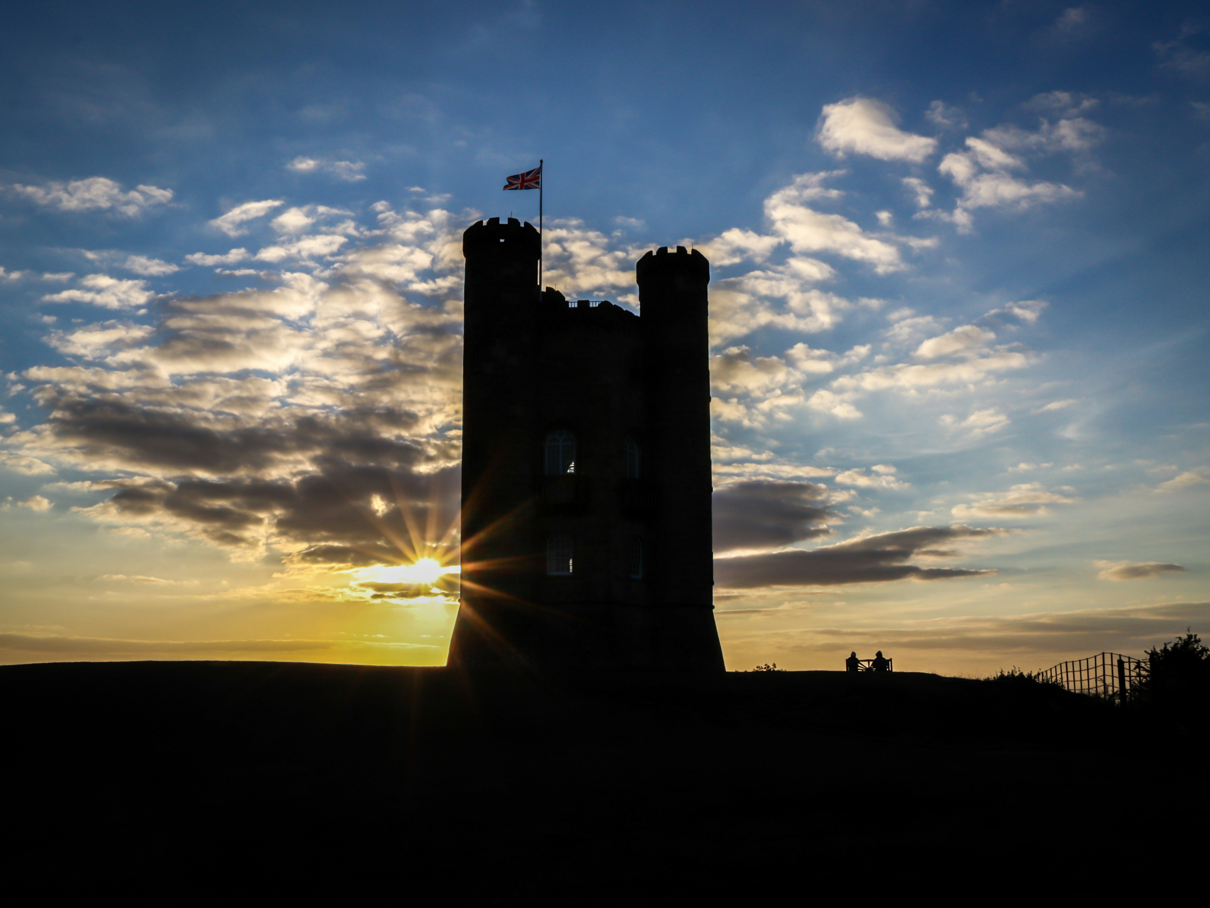 Sunset over Broadway Tower Cotswolds England | Silhouette of a castle tower at sunset with clouds.