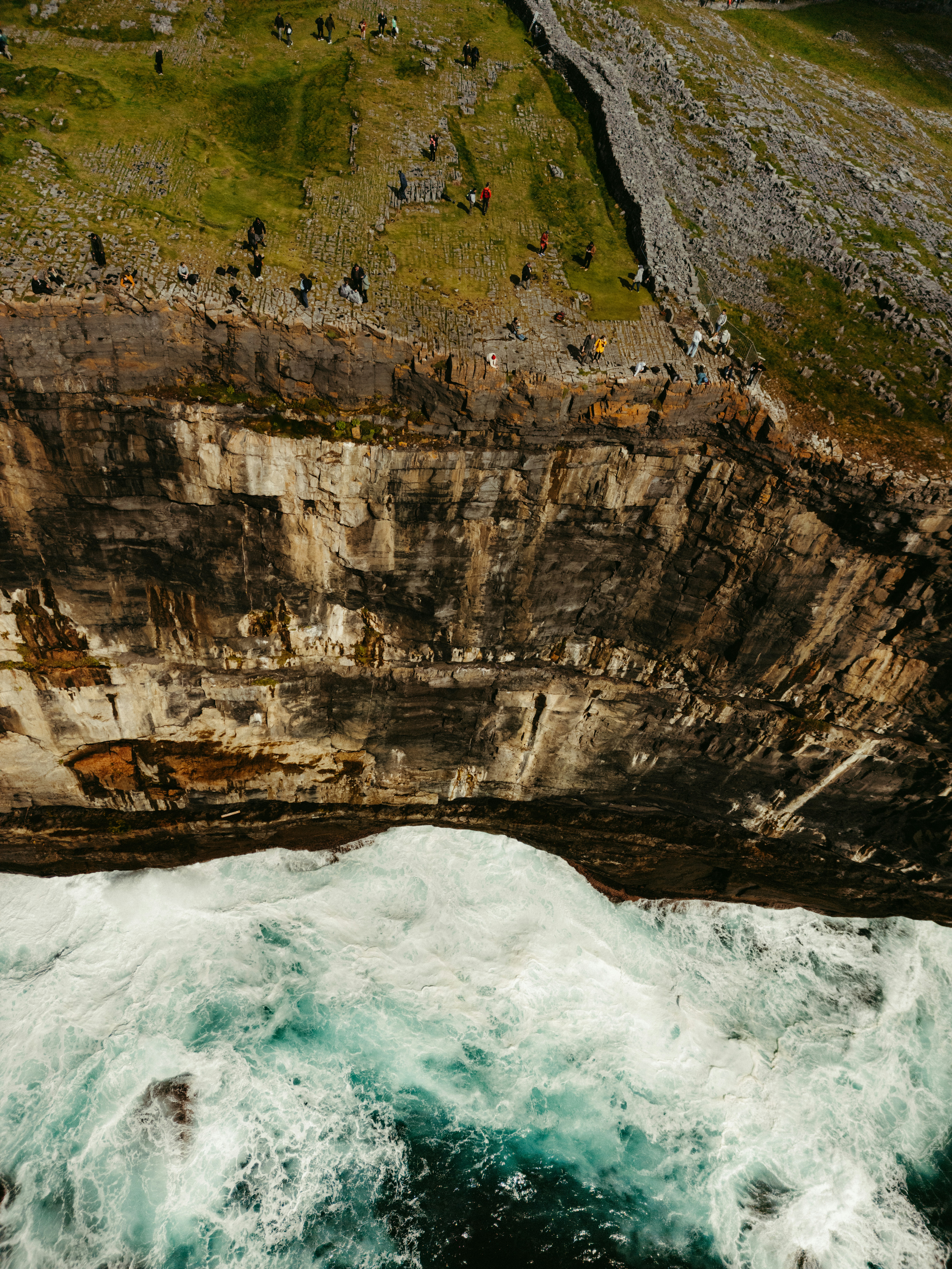 Edge Vista: Visitors Along the Cliff Over the Roaring Sea
