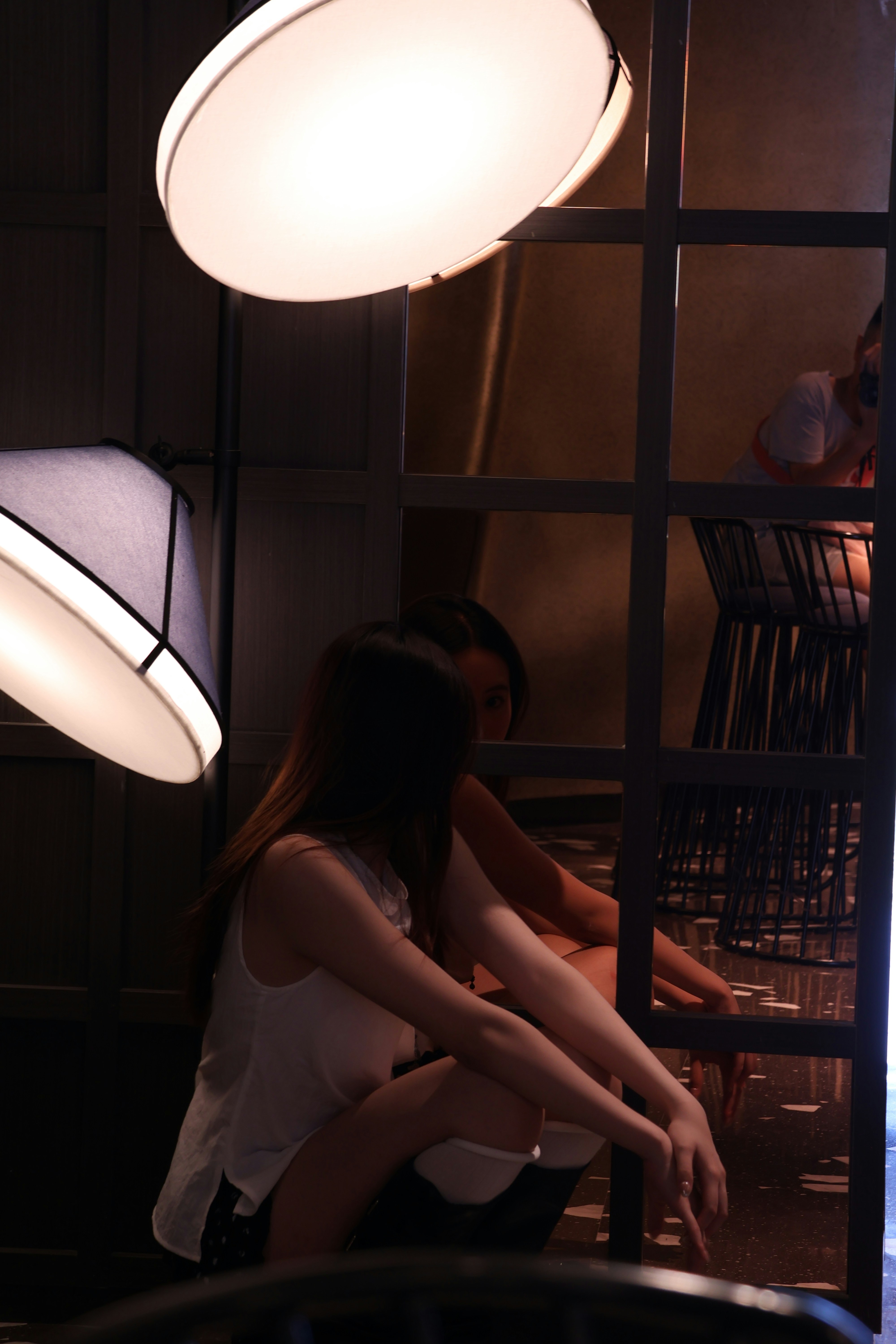 Under Oversized Orbs: Quiet Intimacy by a Glass Partition