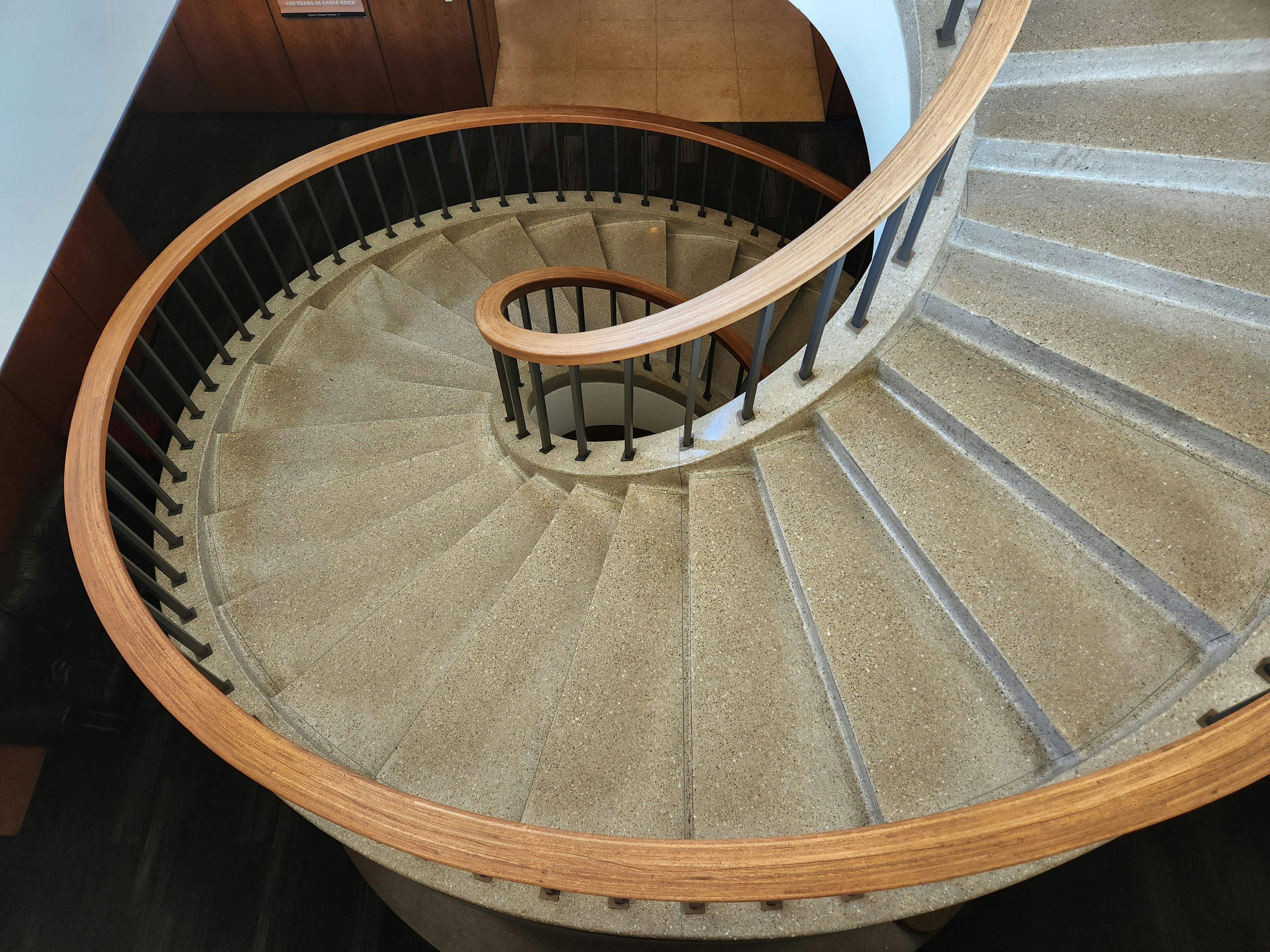 Spiral staircase. | A spiral staircase with carpet and wooden railing.
