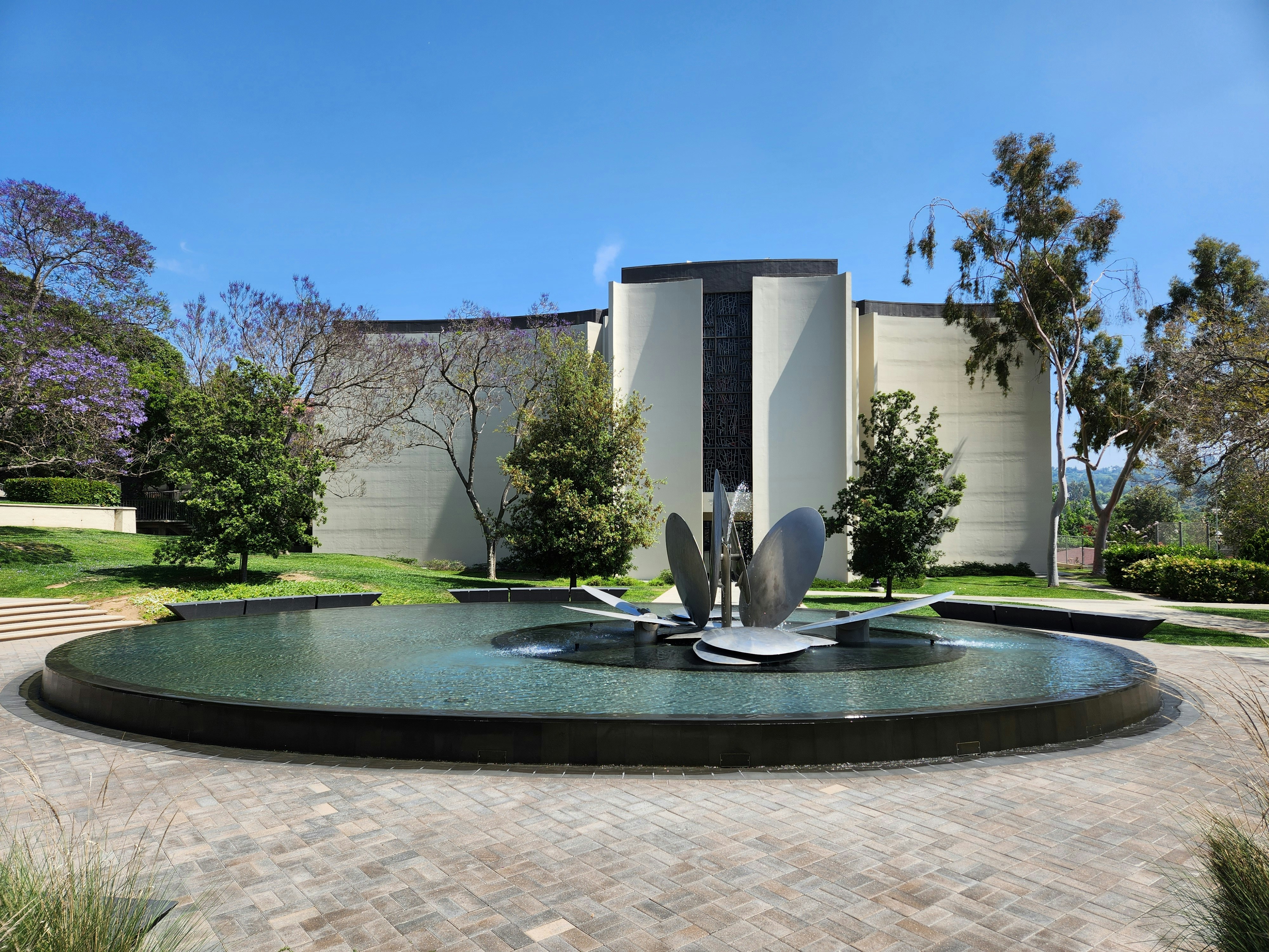 Sculpture and building. | Modern building with a circular water feature and sculpture.