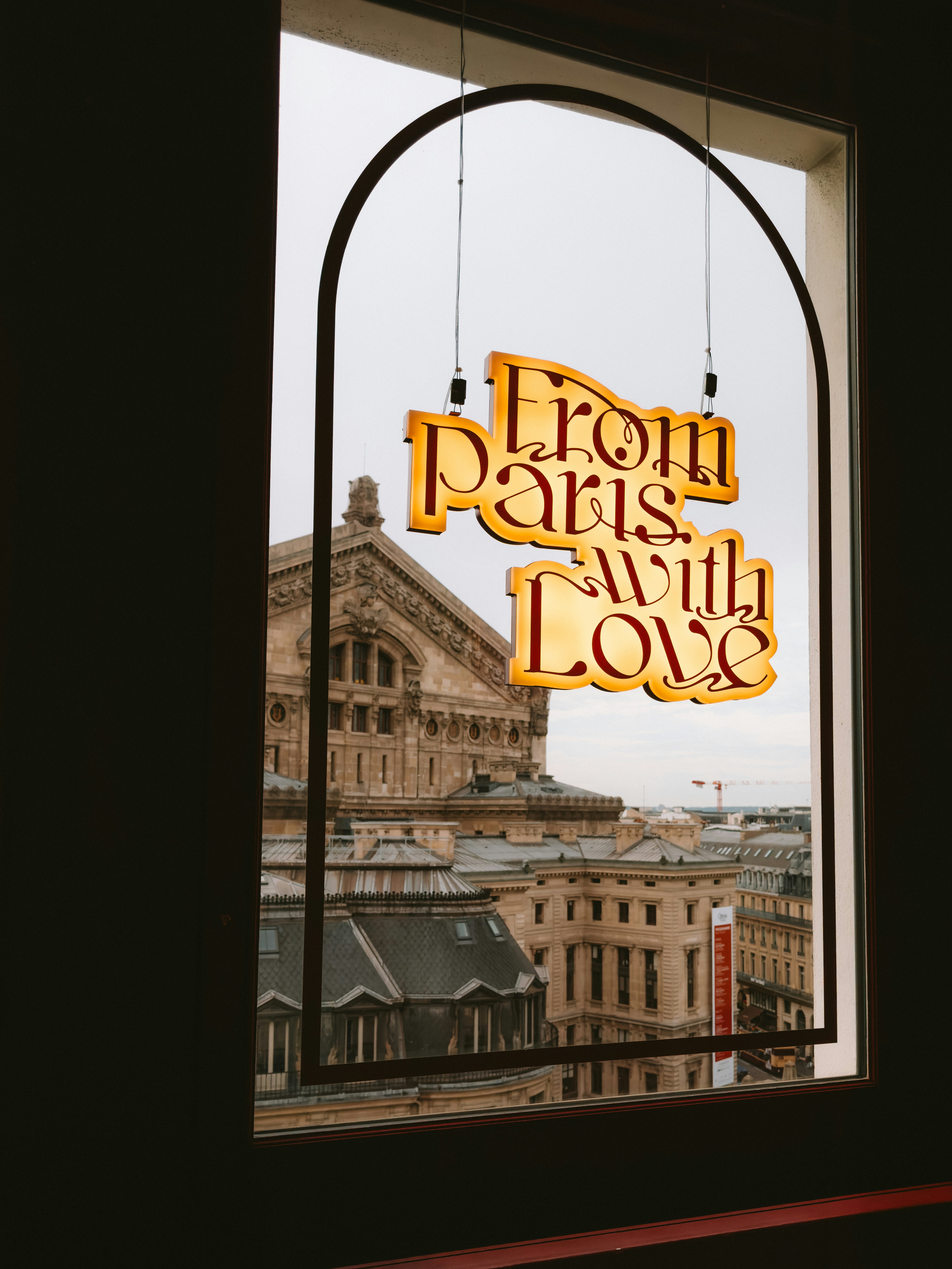Golden sign saying "from paris with love" hangs.
