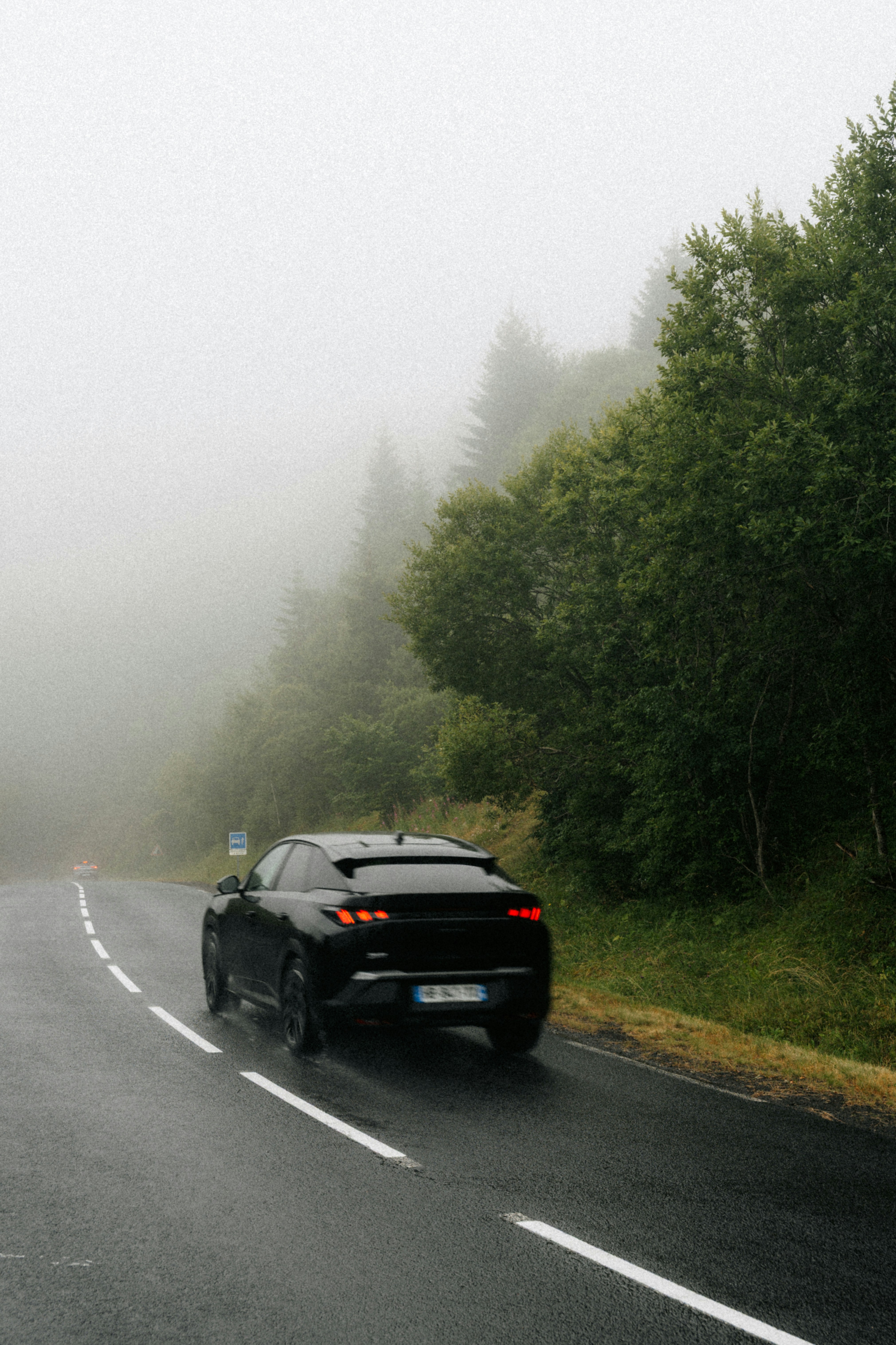 Mist-Drifted Highway: A Black SUV Conquers the Fog