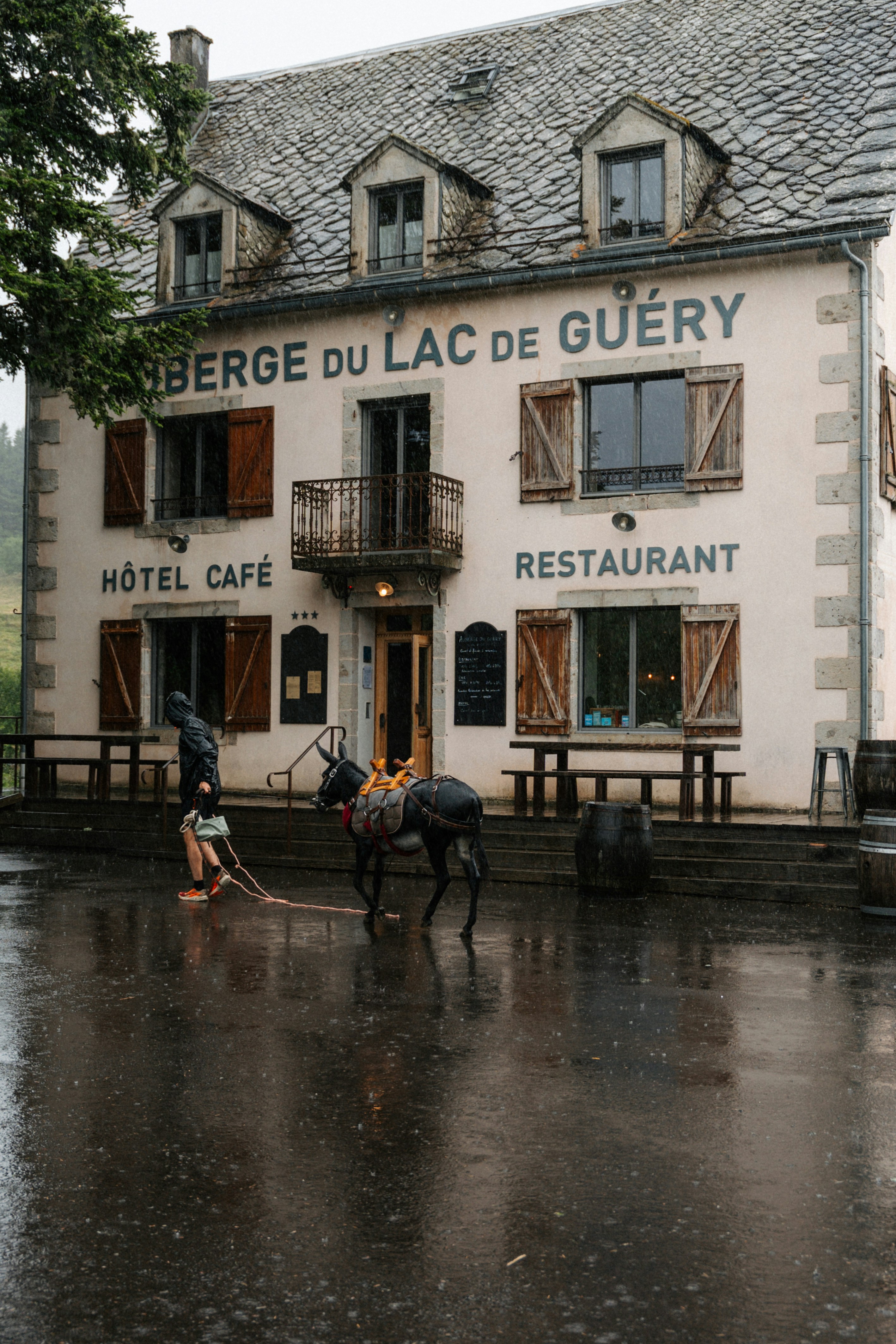 Horse and Handler in Front of a Rustic Hotel Facade