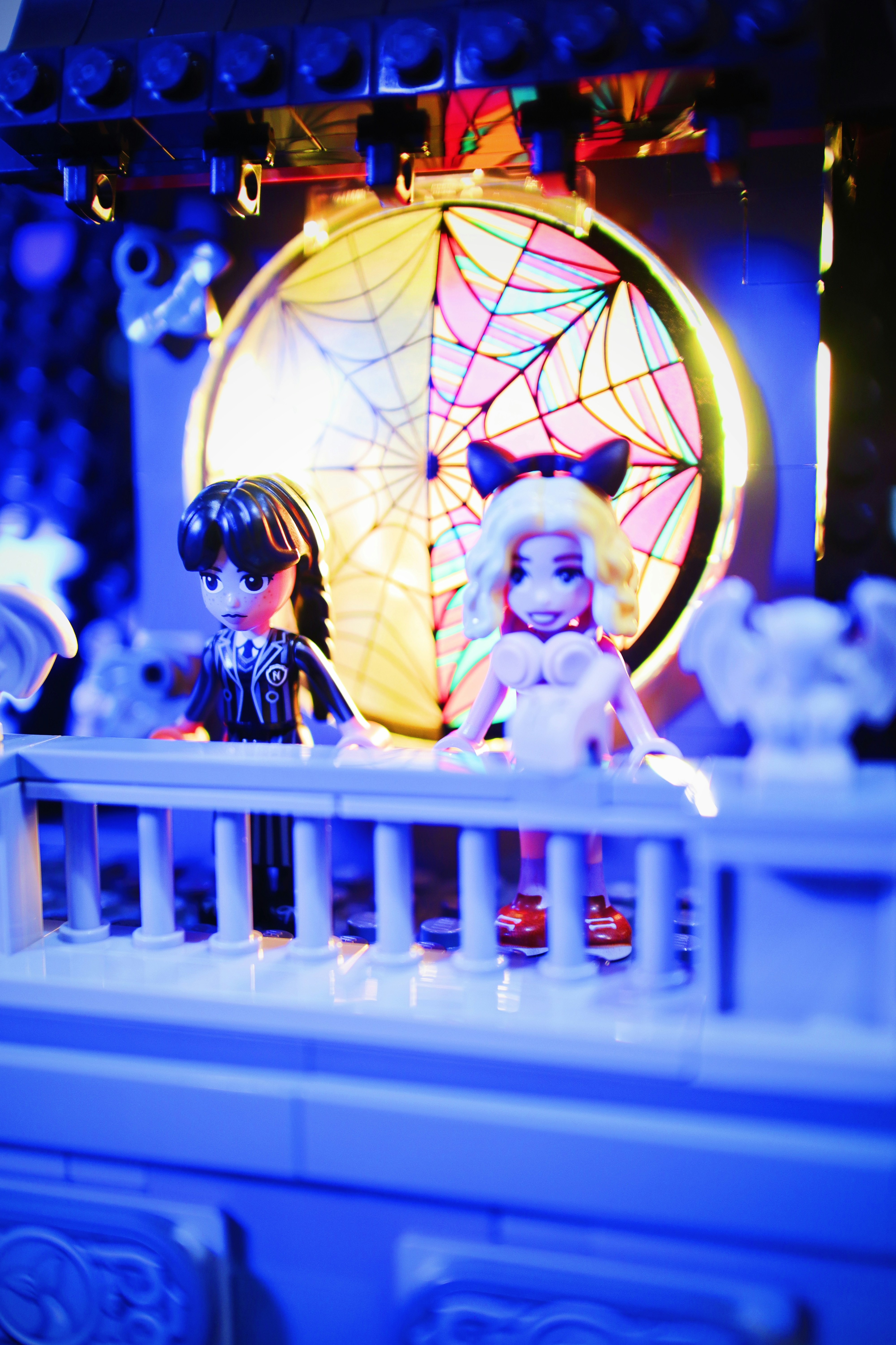 Wednesday & Enid's Dorm Room 76781 | Two figures stand on a balcony with stained glass window.