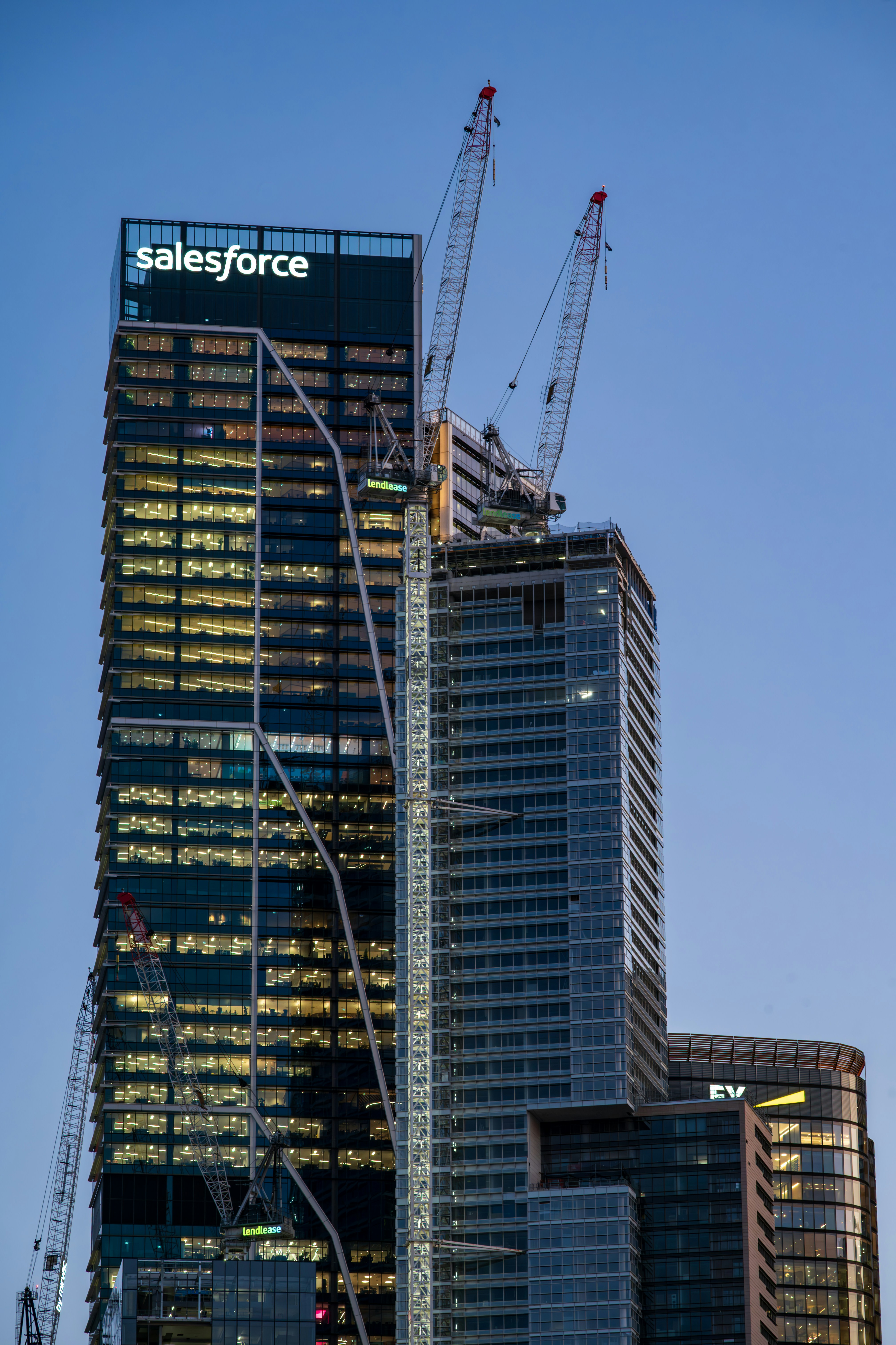 Skyscrapers under construction with cranes against blue sky