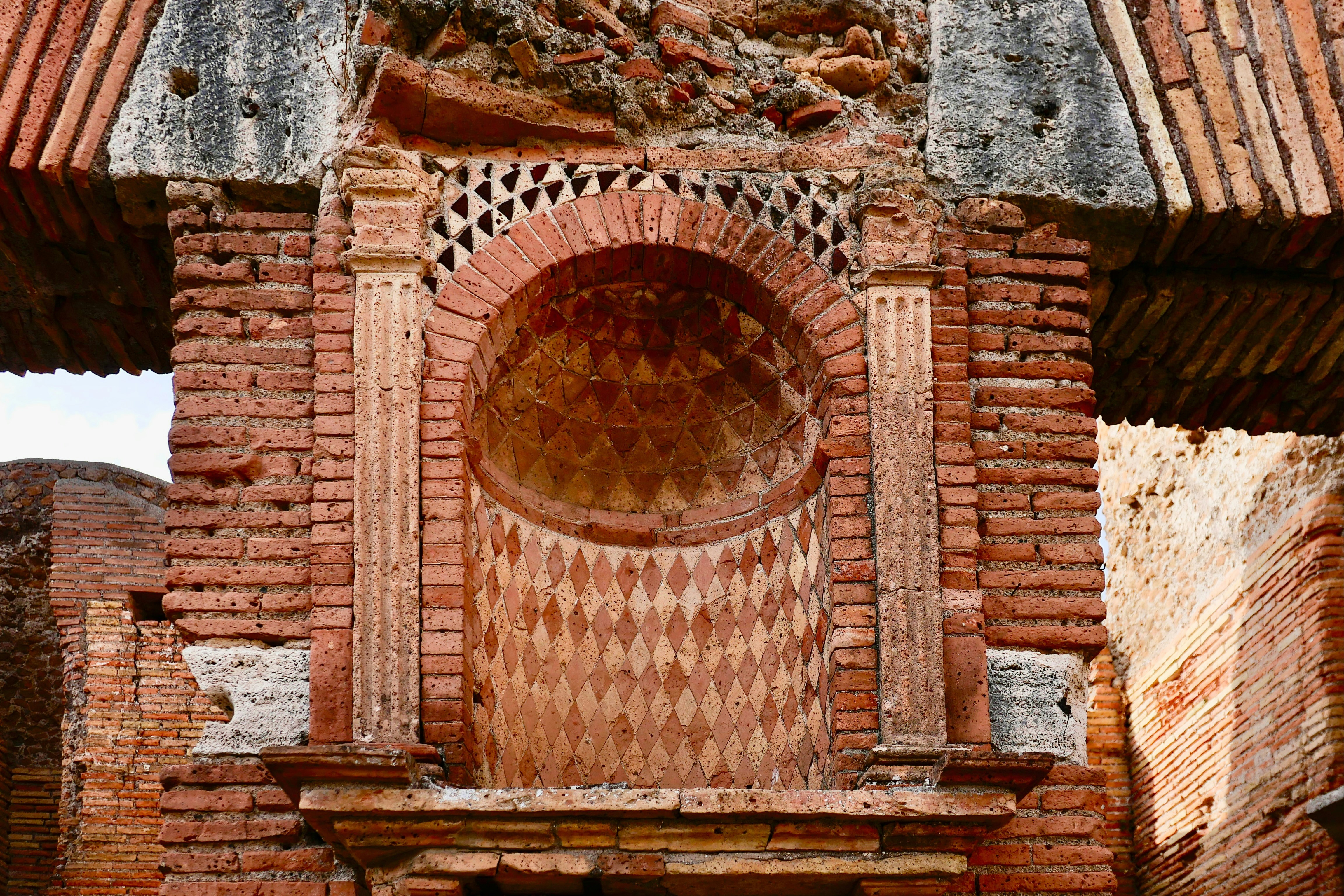 Ancient brick structure with arched niche and patterned details. photo ...