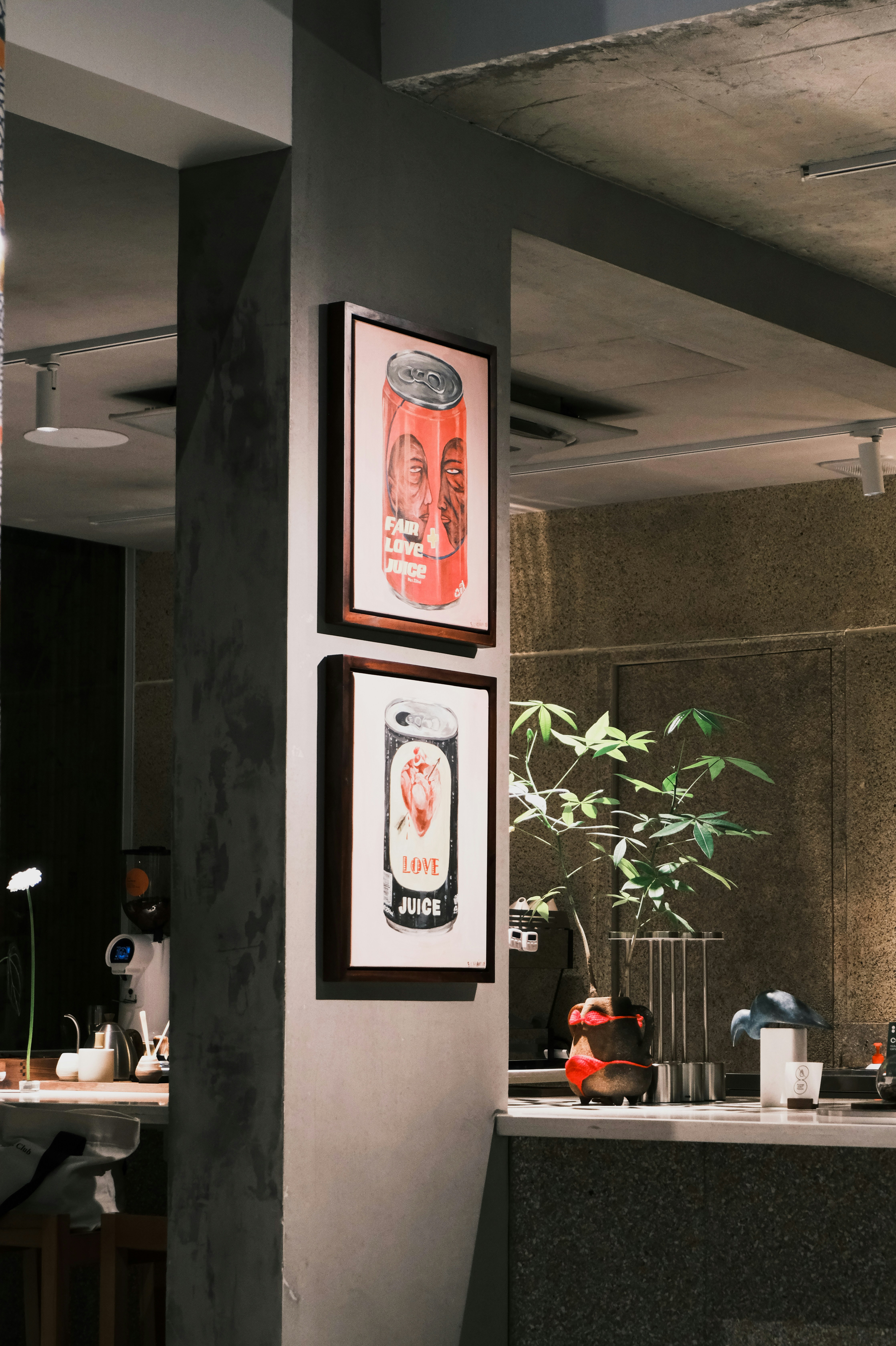 Two framed artistic cans hang on wall.