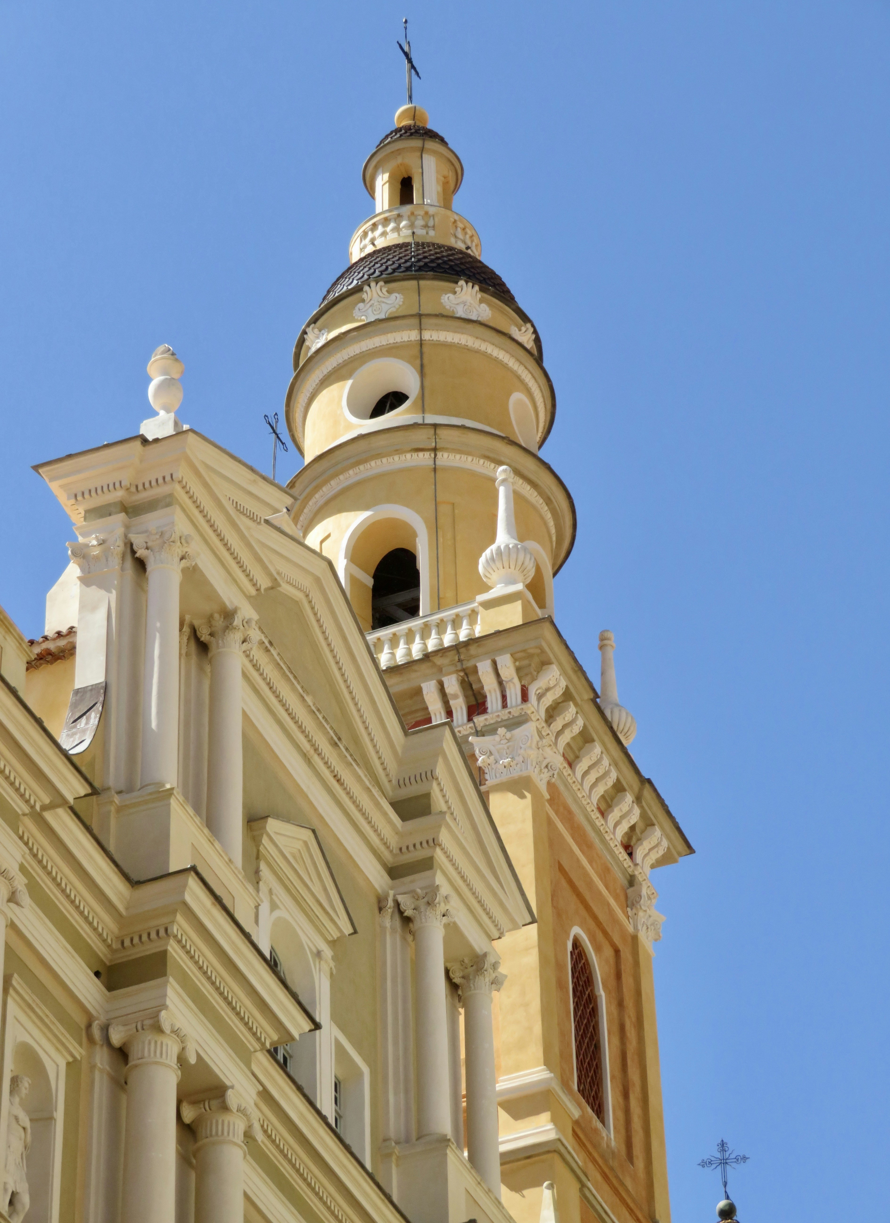 Yellow church tower against a clear blue sky