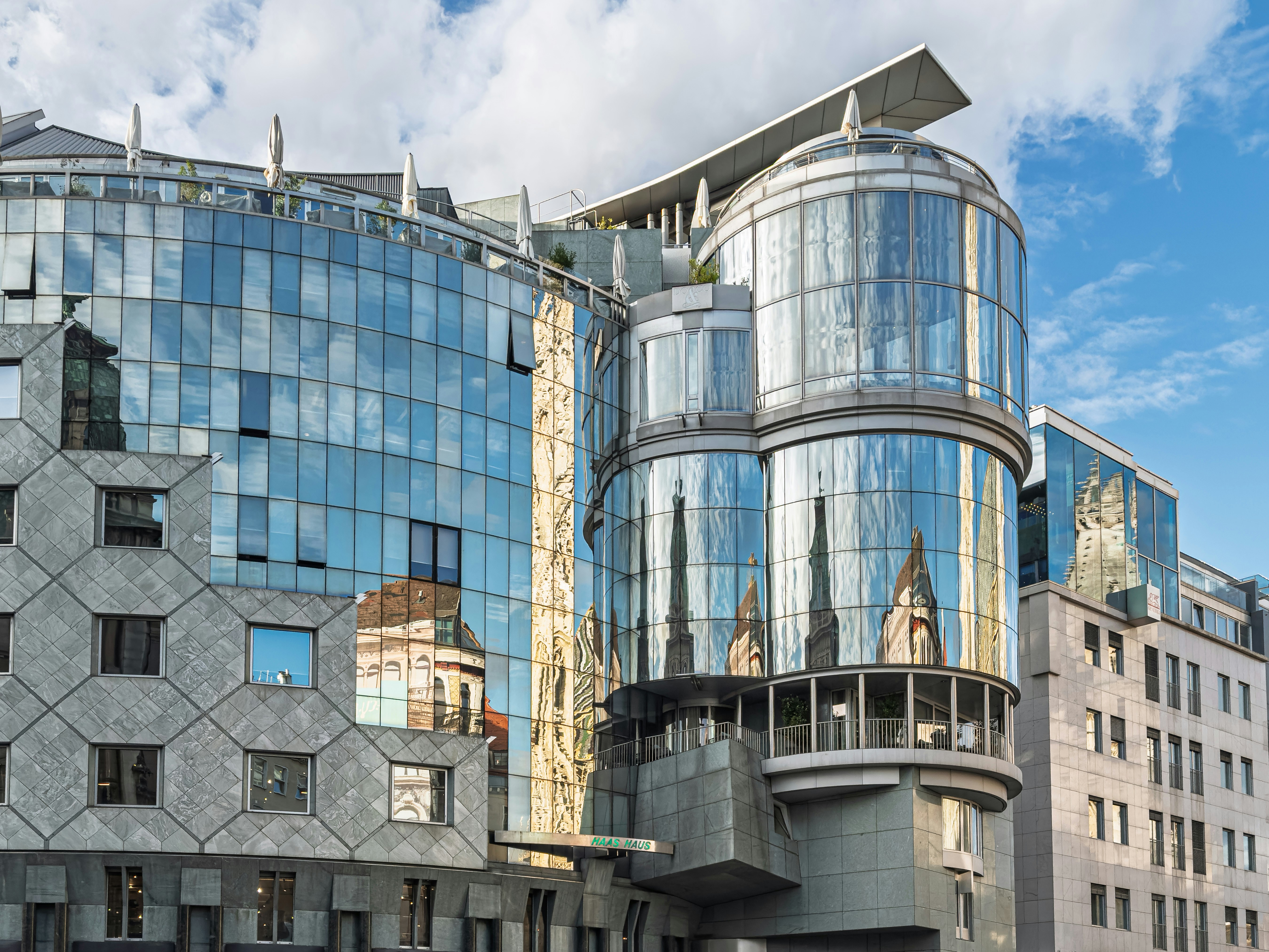 Modern building with reflective glass facade and unique architecture.
