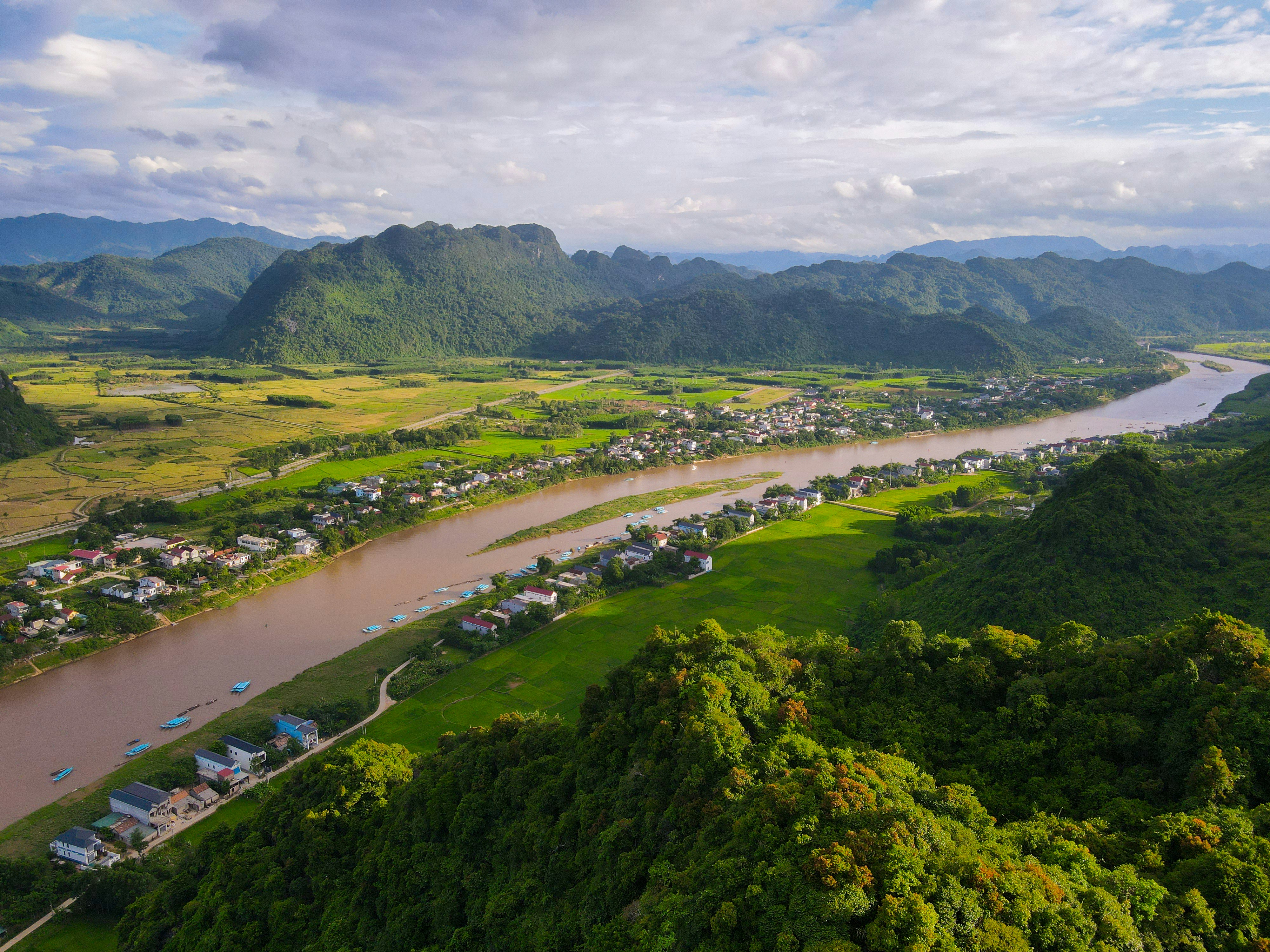 River Ribbon Through a Verdant Valley Beneath Limestone Peaks