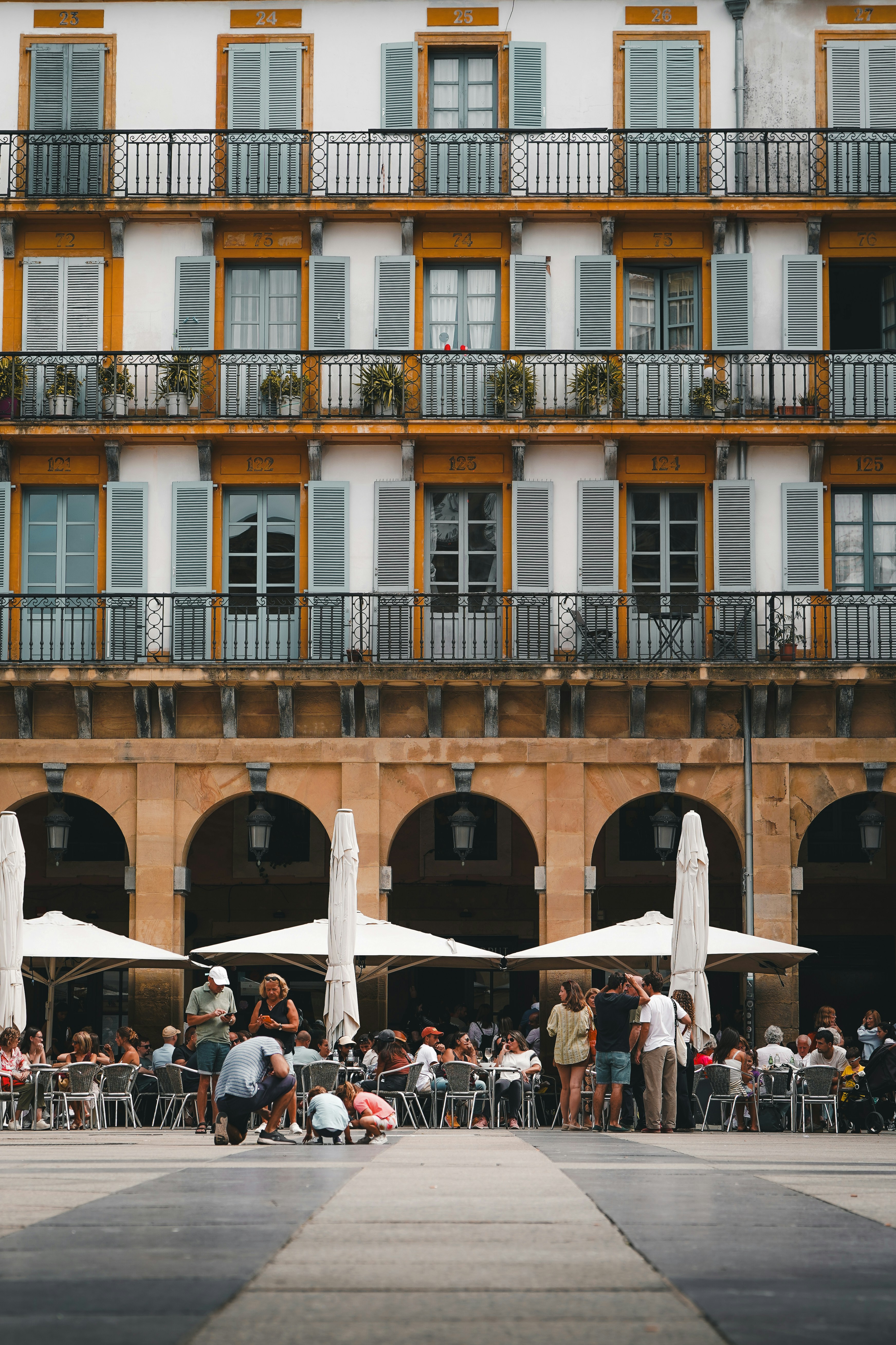 People dining at outdoor cafe under arched building