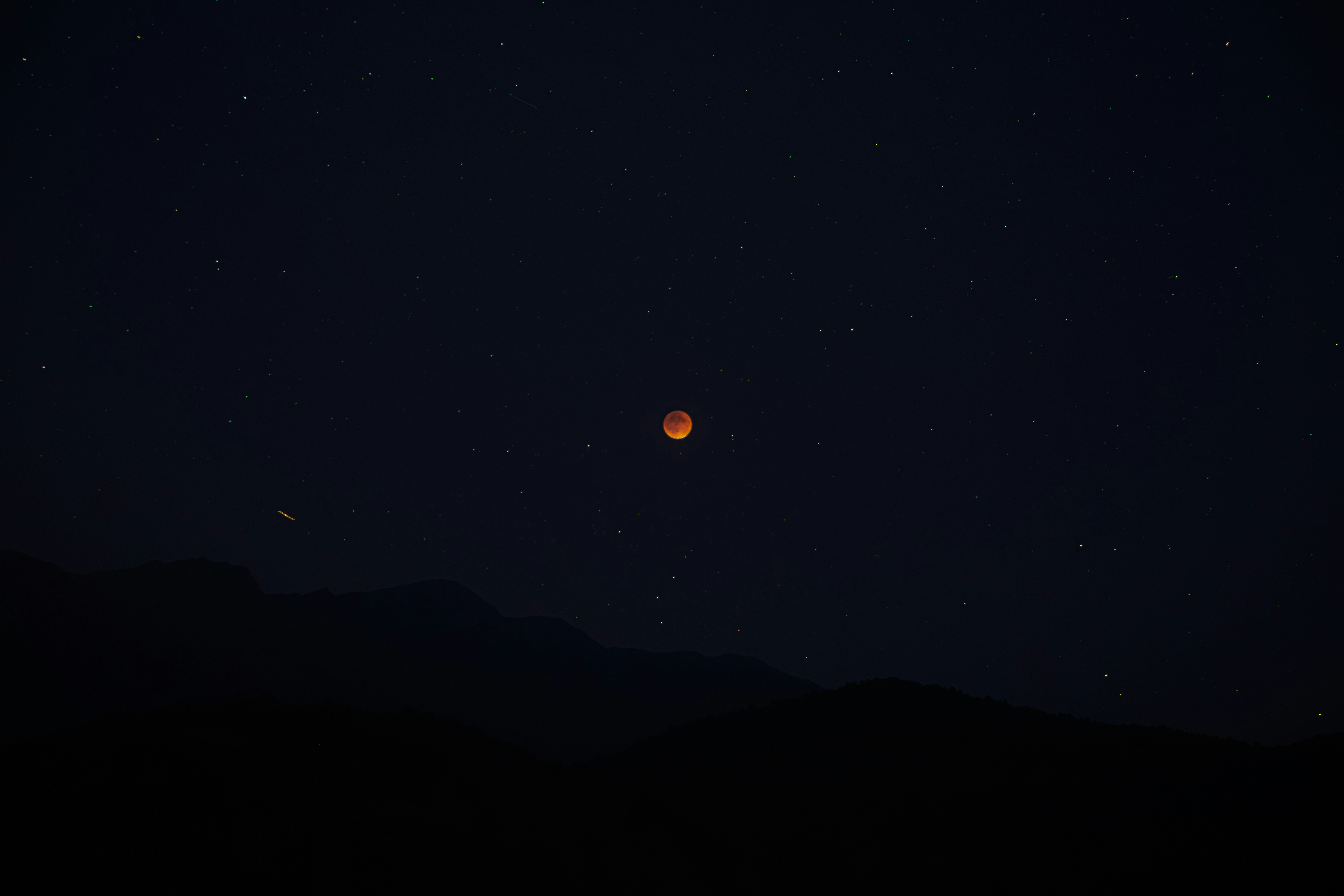 Blood moon visible in a starry night sky