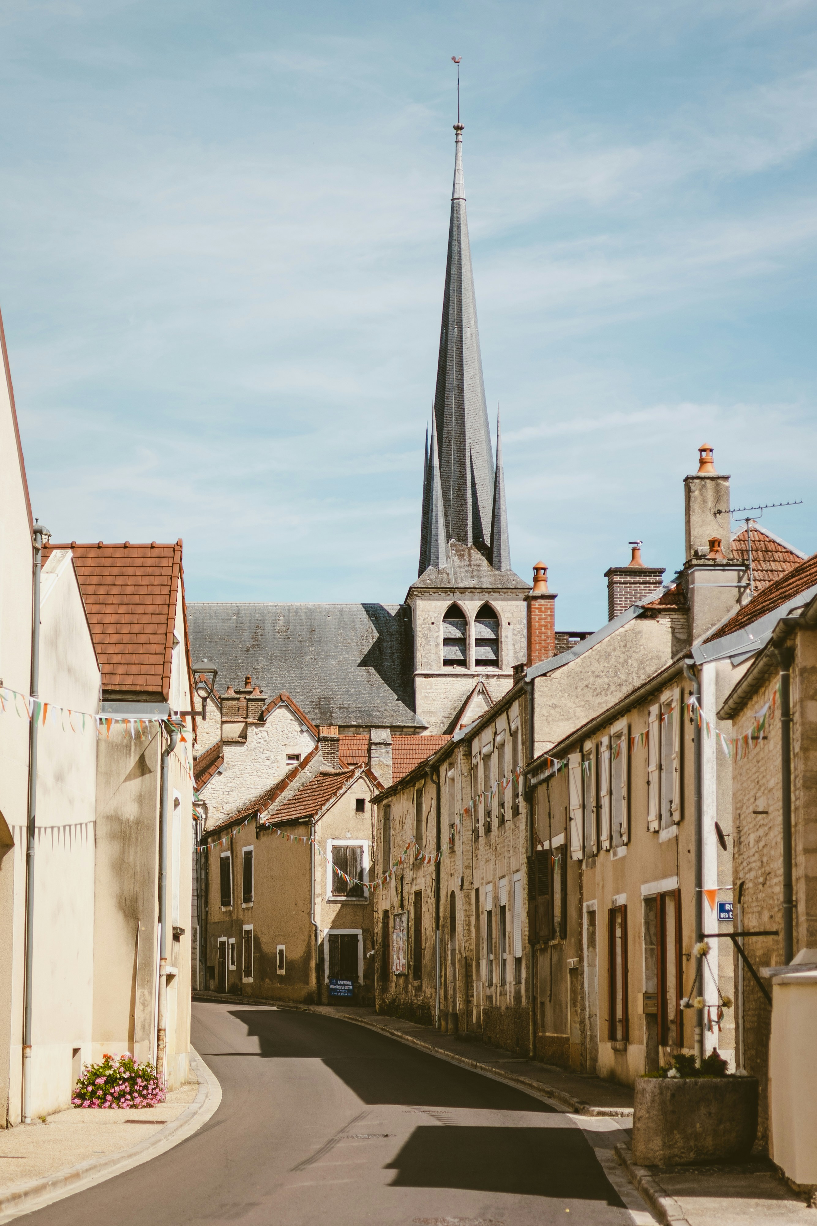 Narrow street in a european village with church steeple.