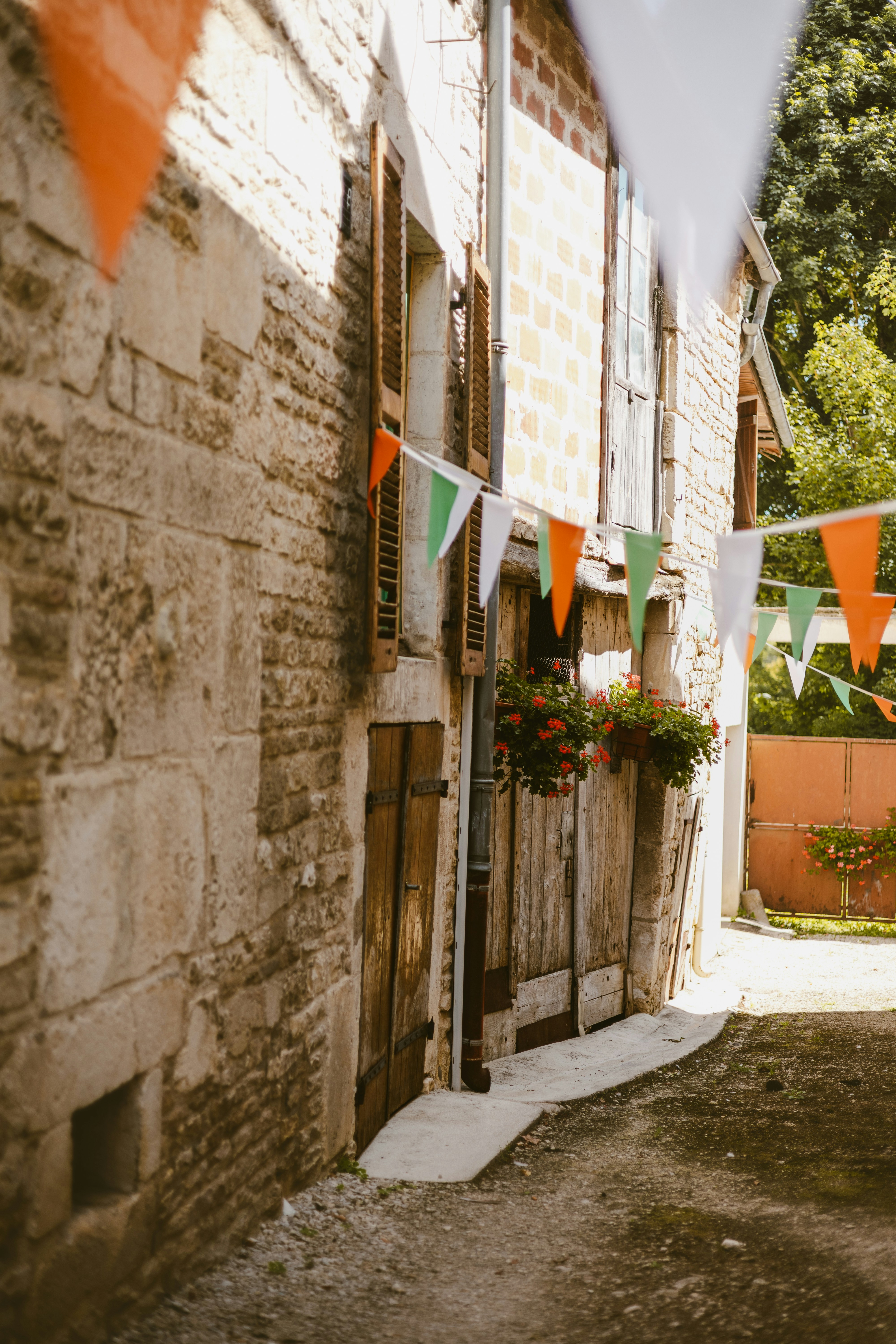 Stone building with festive bunting and flower baskets.