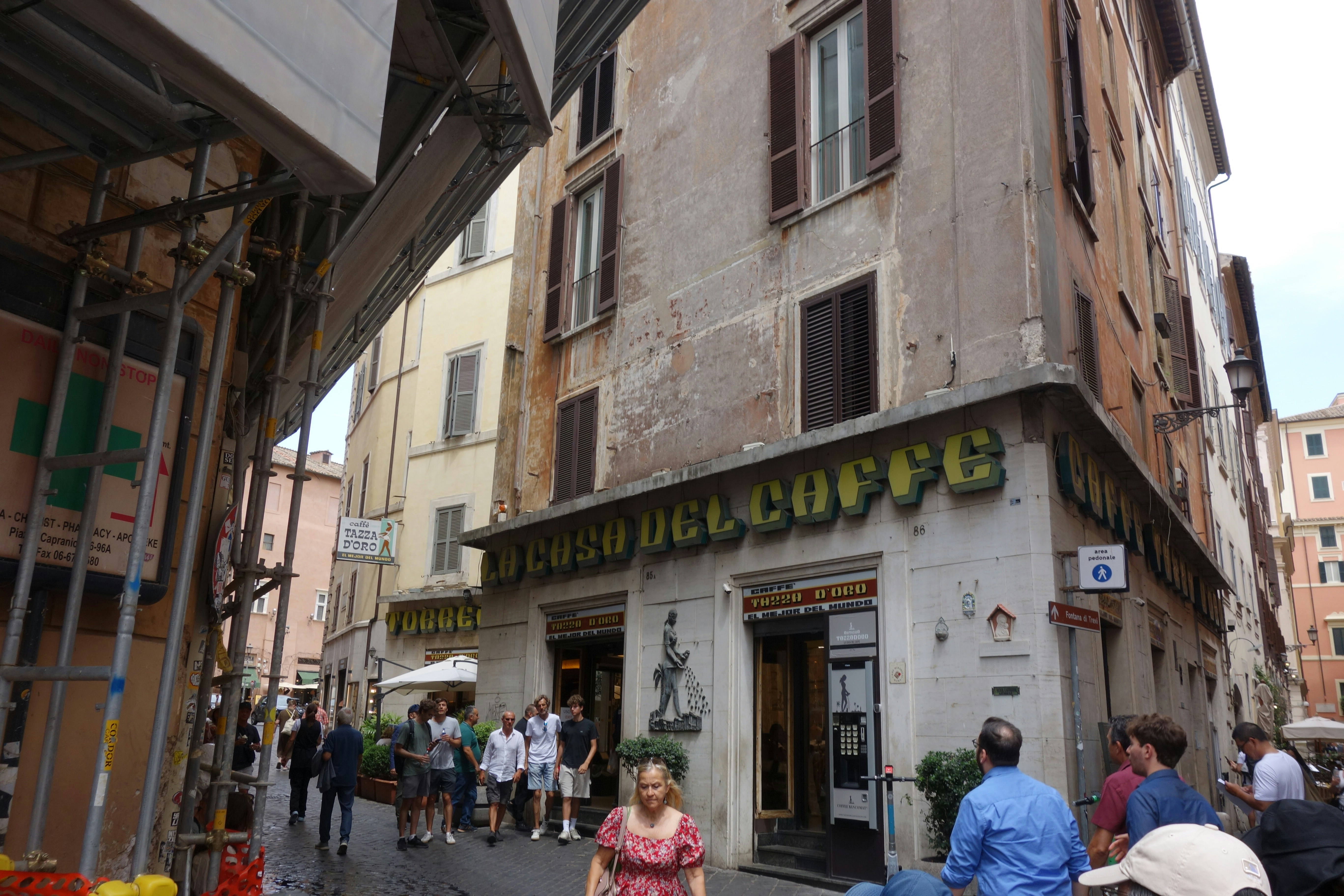 Cafe Corner Pulse: Pedestrians on a Sunlit Cobblestone Street