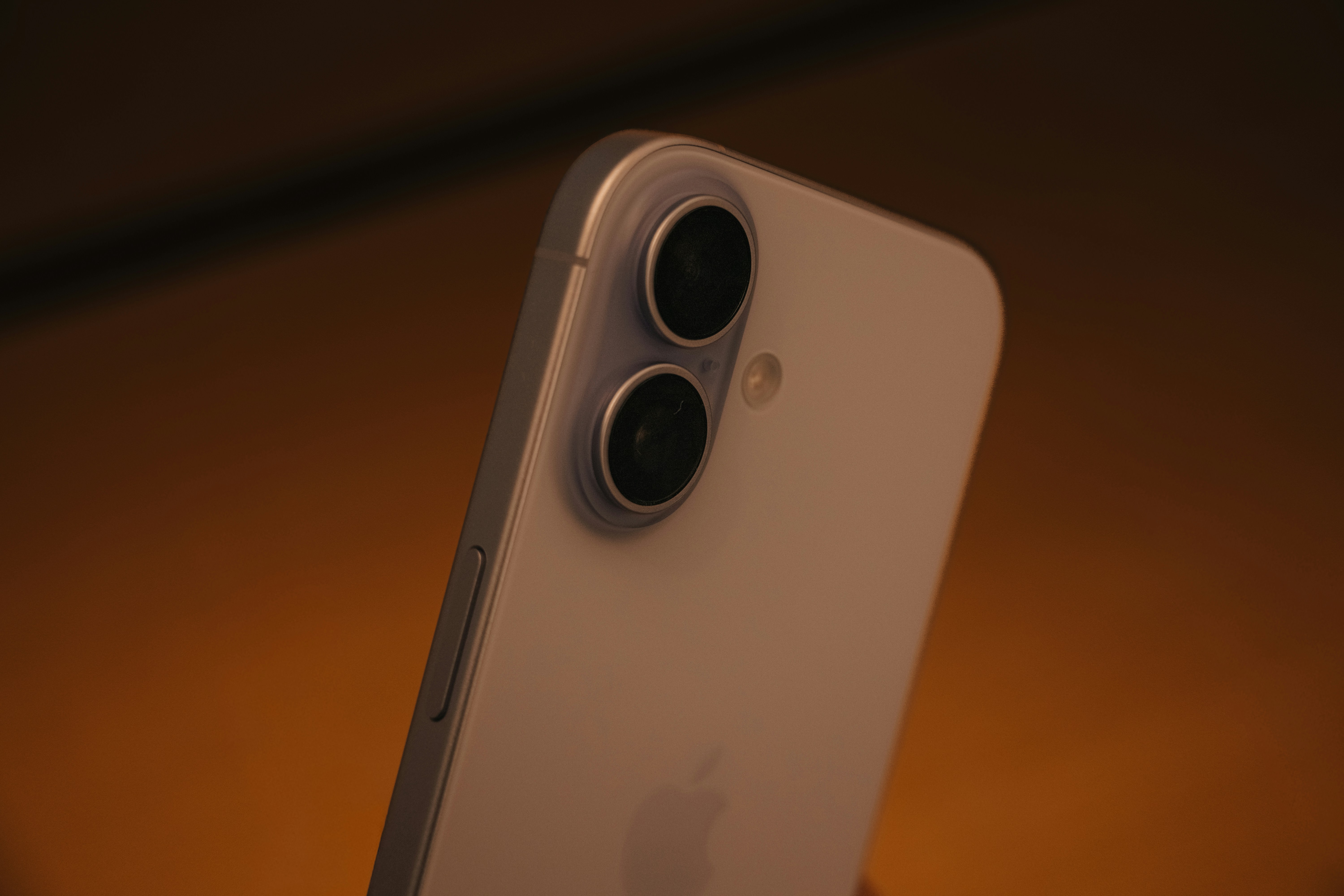 The iPhone 17 is blue, with a clean finish and dual-lens camera modules in a minimalist style. | Close-up of a smartphone's dual camera system.