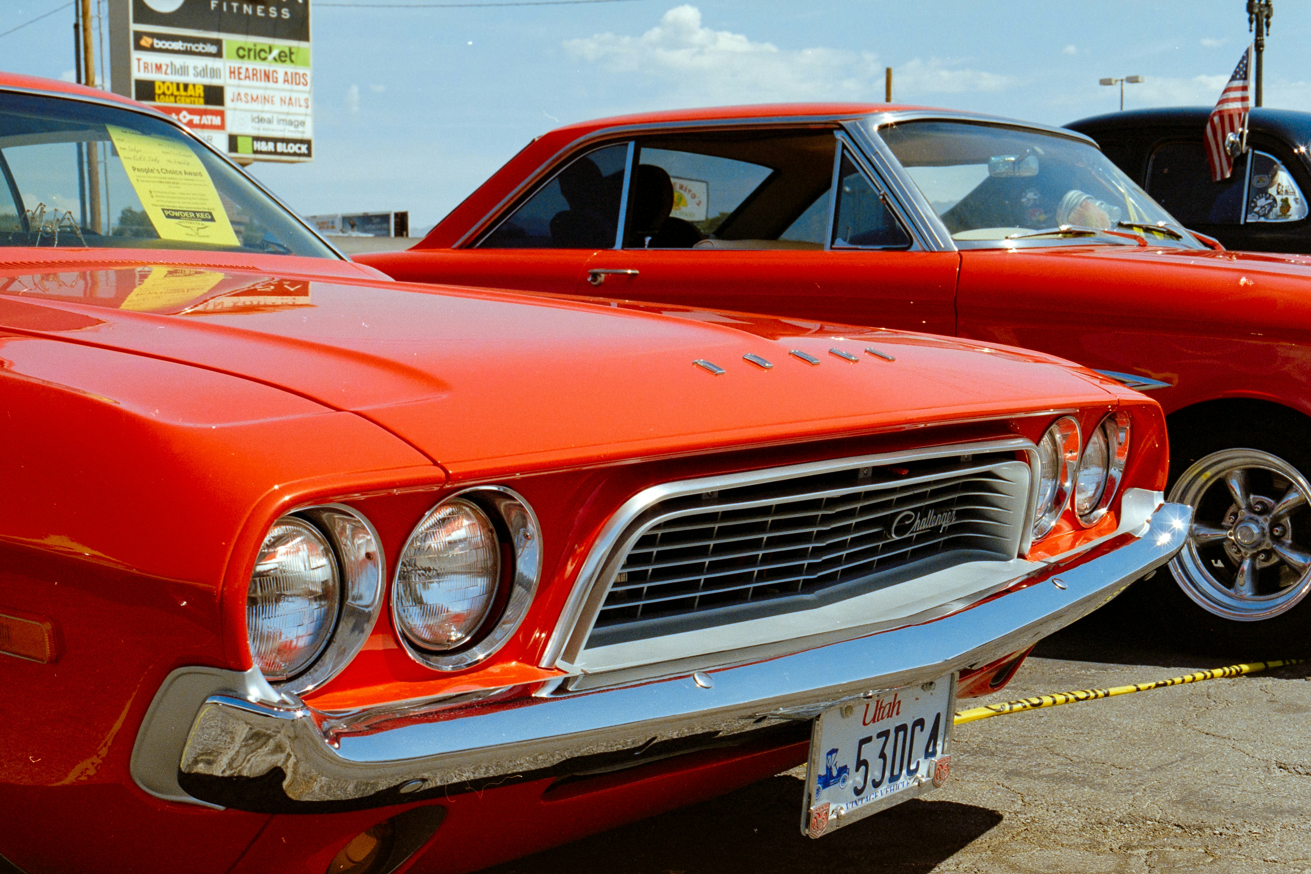 Two vintage red cars parked side by side