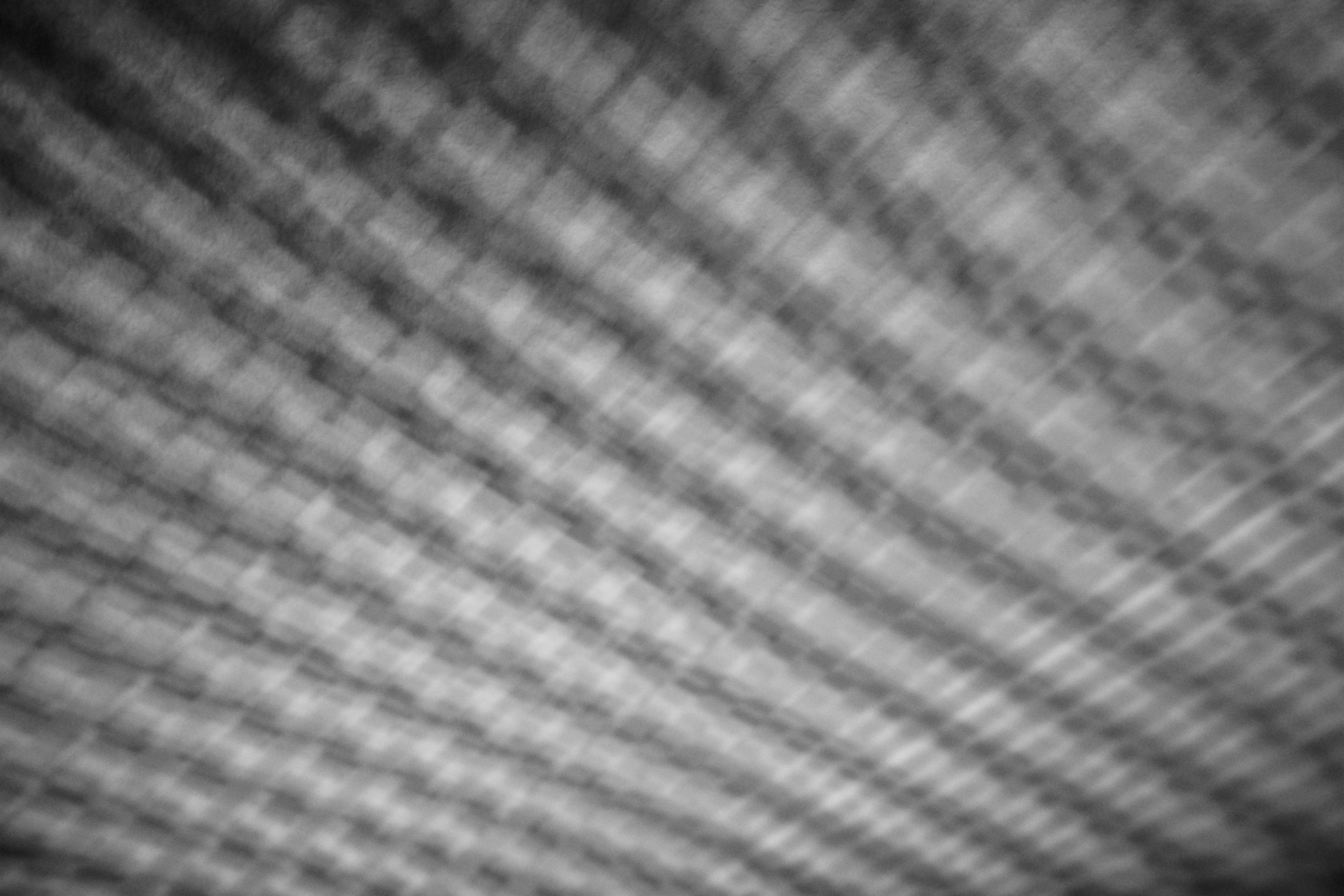 Abstract texture showcasing a series of blurred lines creating a rhythmic pattern. The interplay of light and shadow enhances the visual depth.