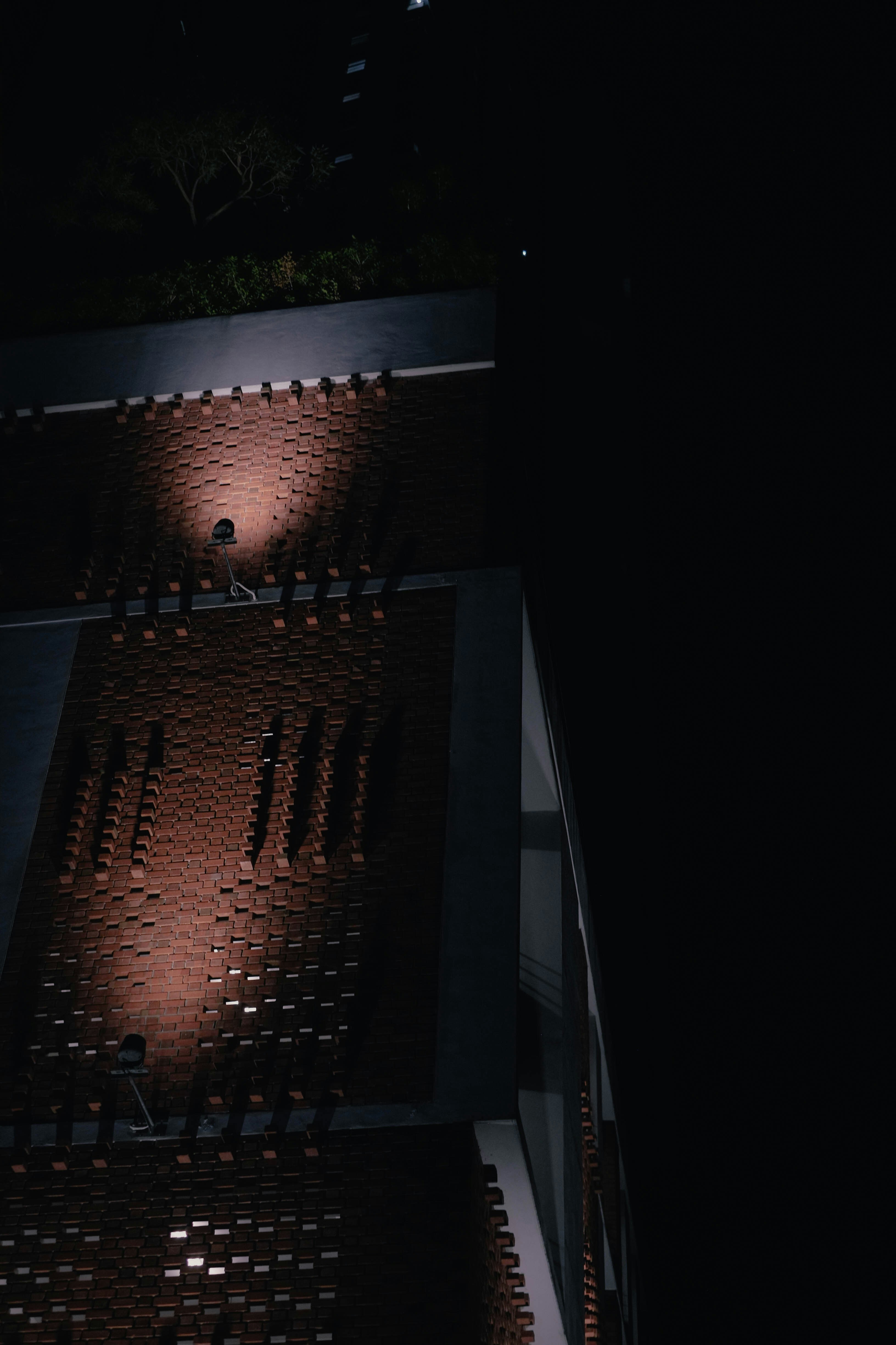 Solitary Glow on Brick Facade: Nighttime Geometry