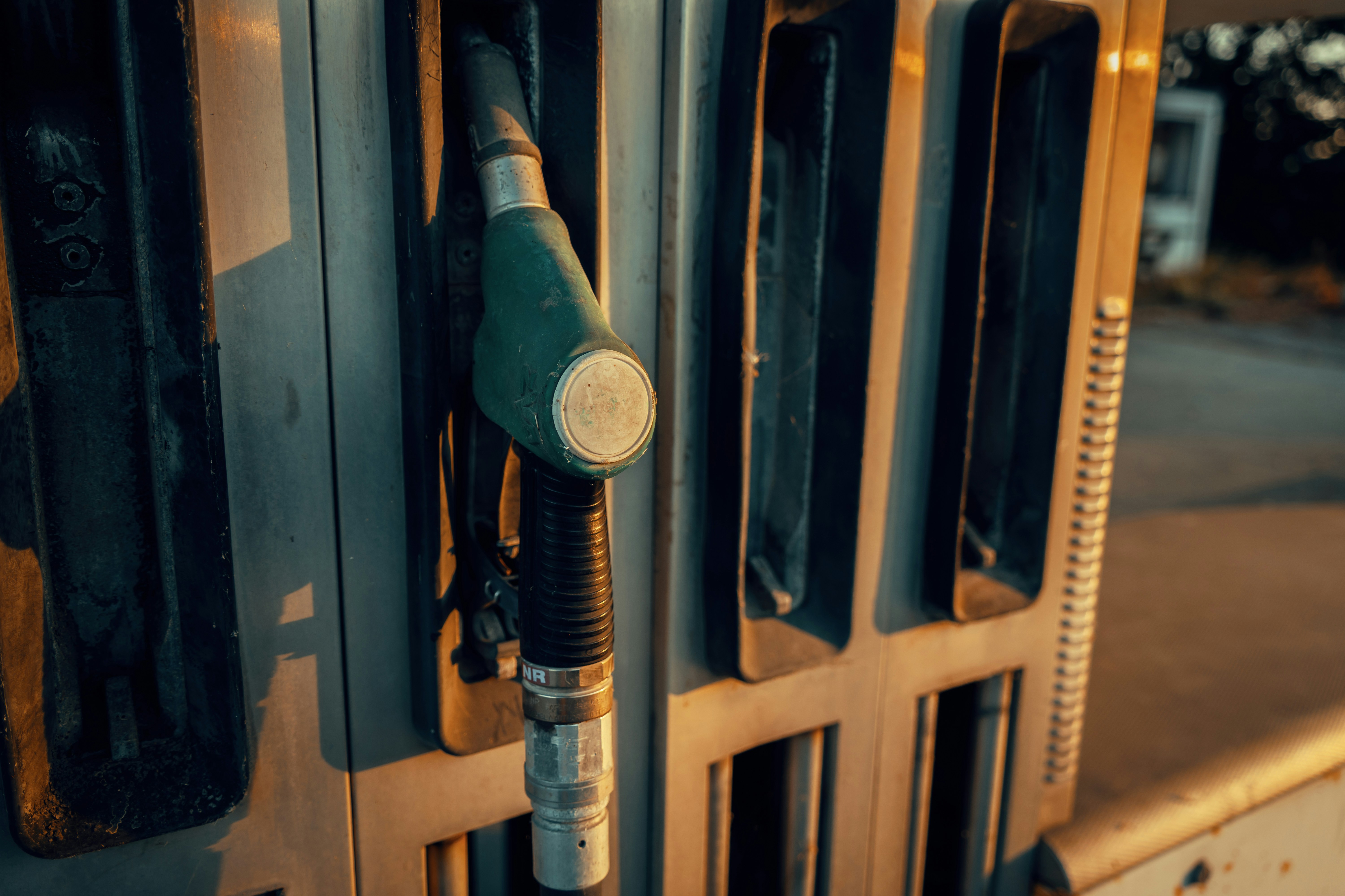 A close-up of a gas pump nozzle at a station.