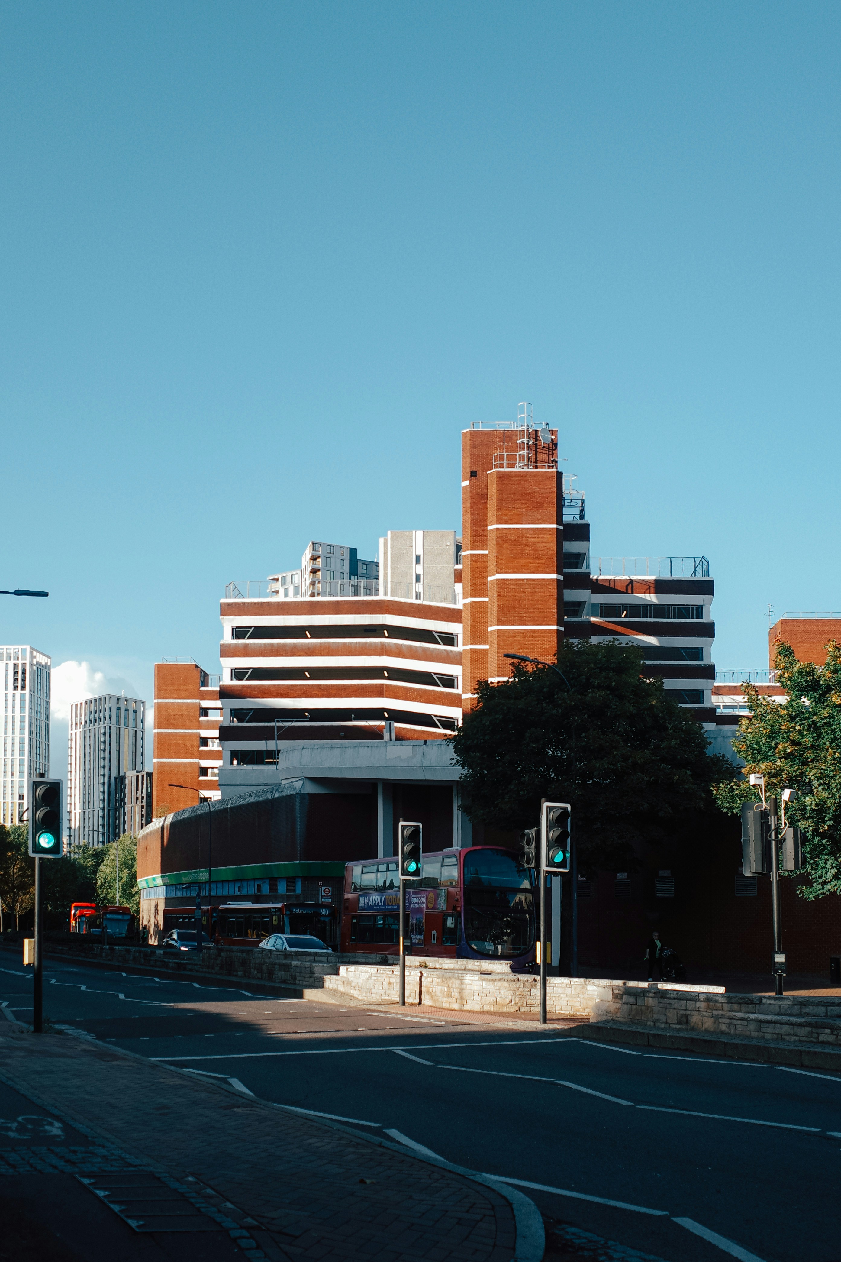 Sun setting on Lewisham Shopping Centre cross walk | Modern buildings and traffic lights on a street.