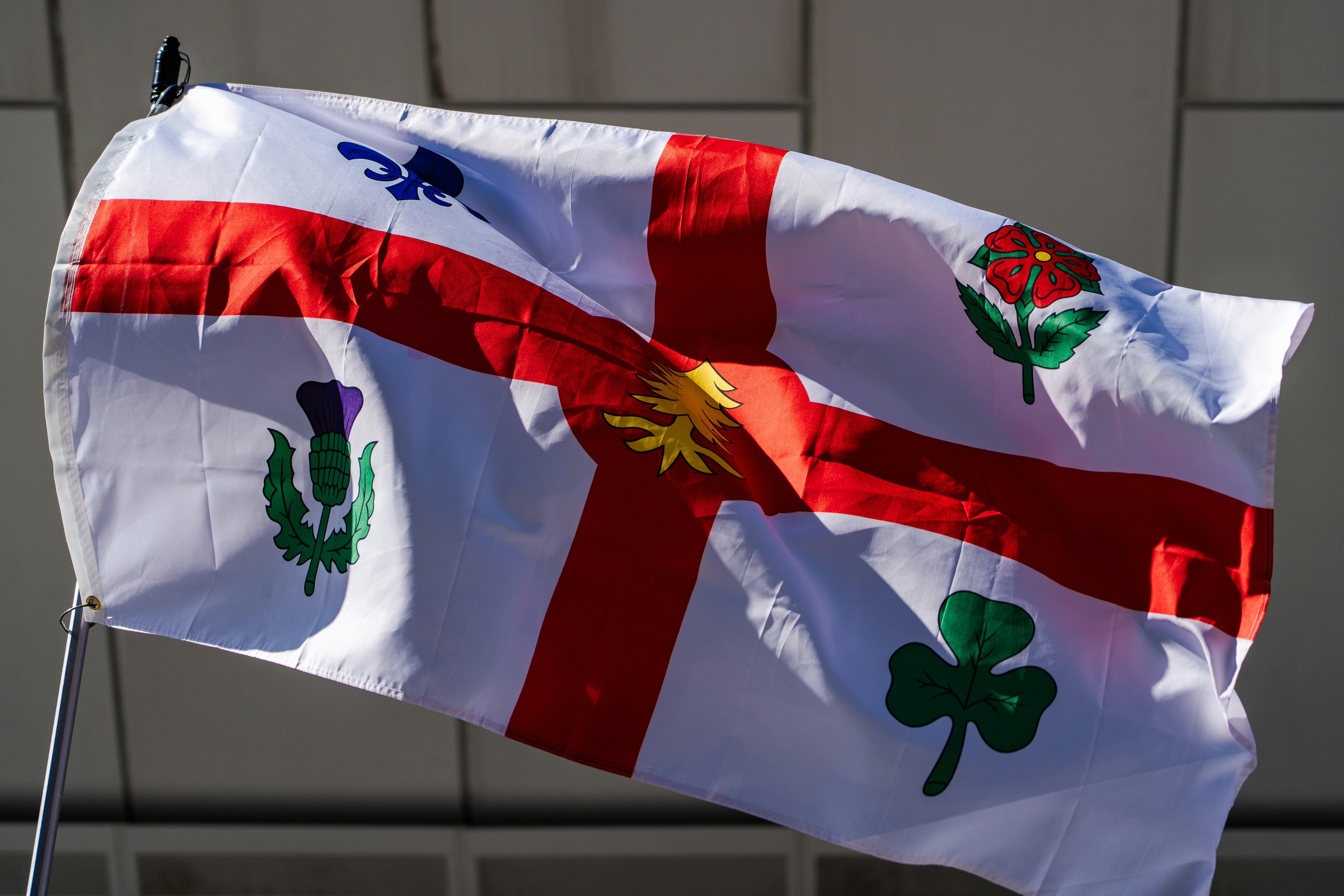 the flag of Montreal | A white flag with a red cross and symbols.