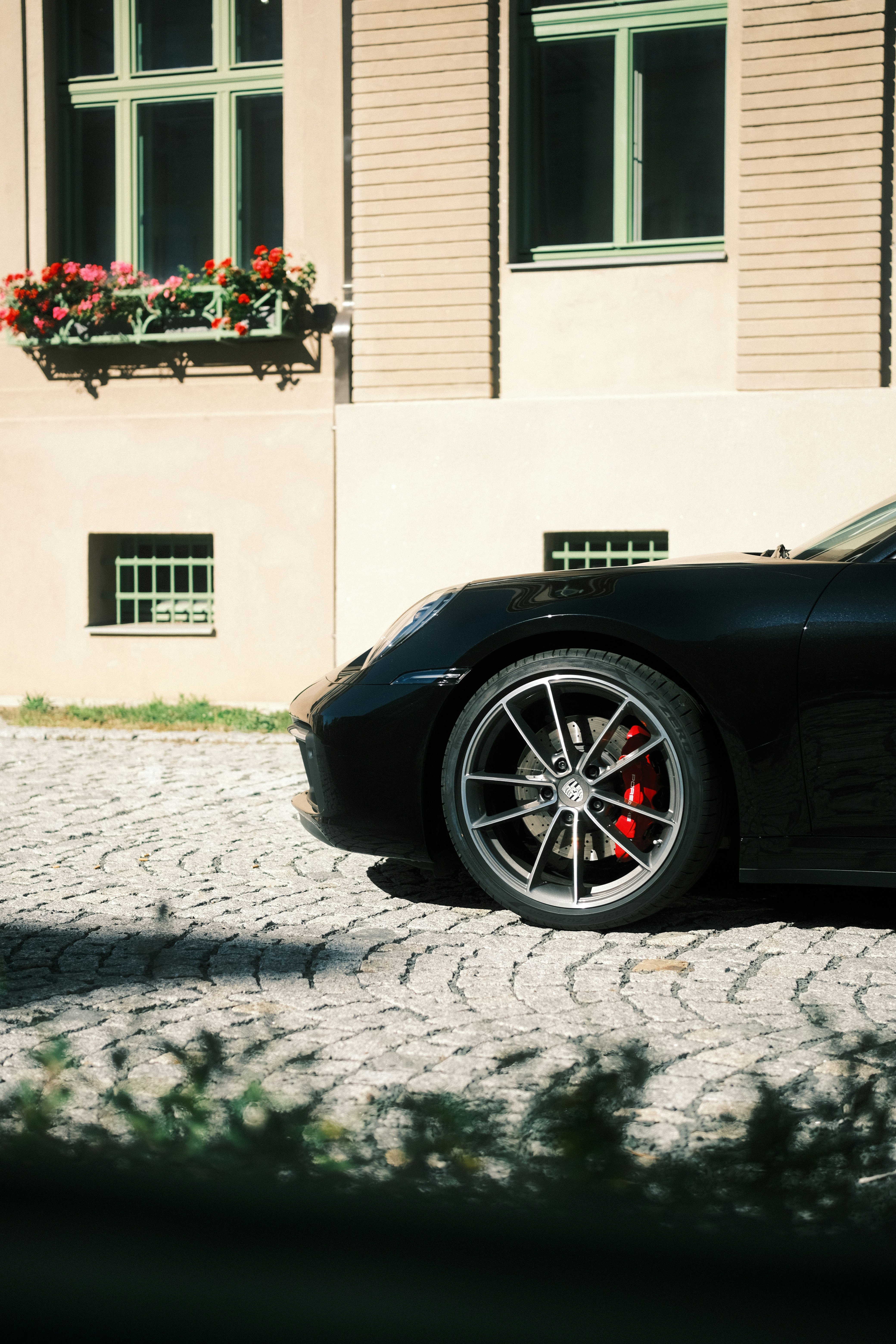 Porsche 911 Carrera S / 4S | Black sports car parked on cobblestone street.