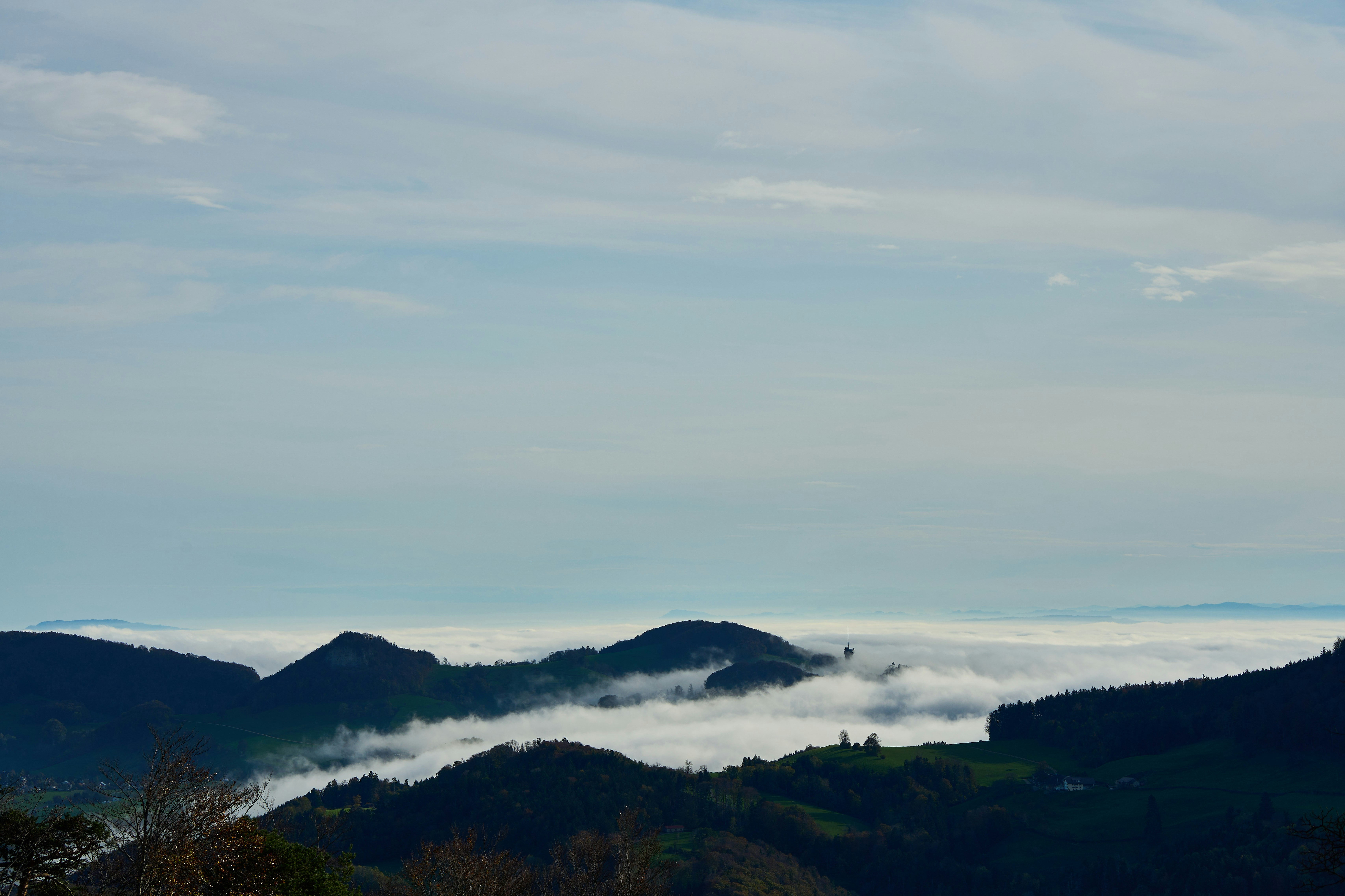 Rolling hills covered in mist under a cloudy sky
