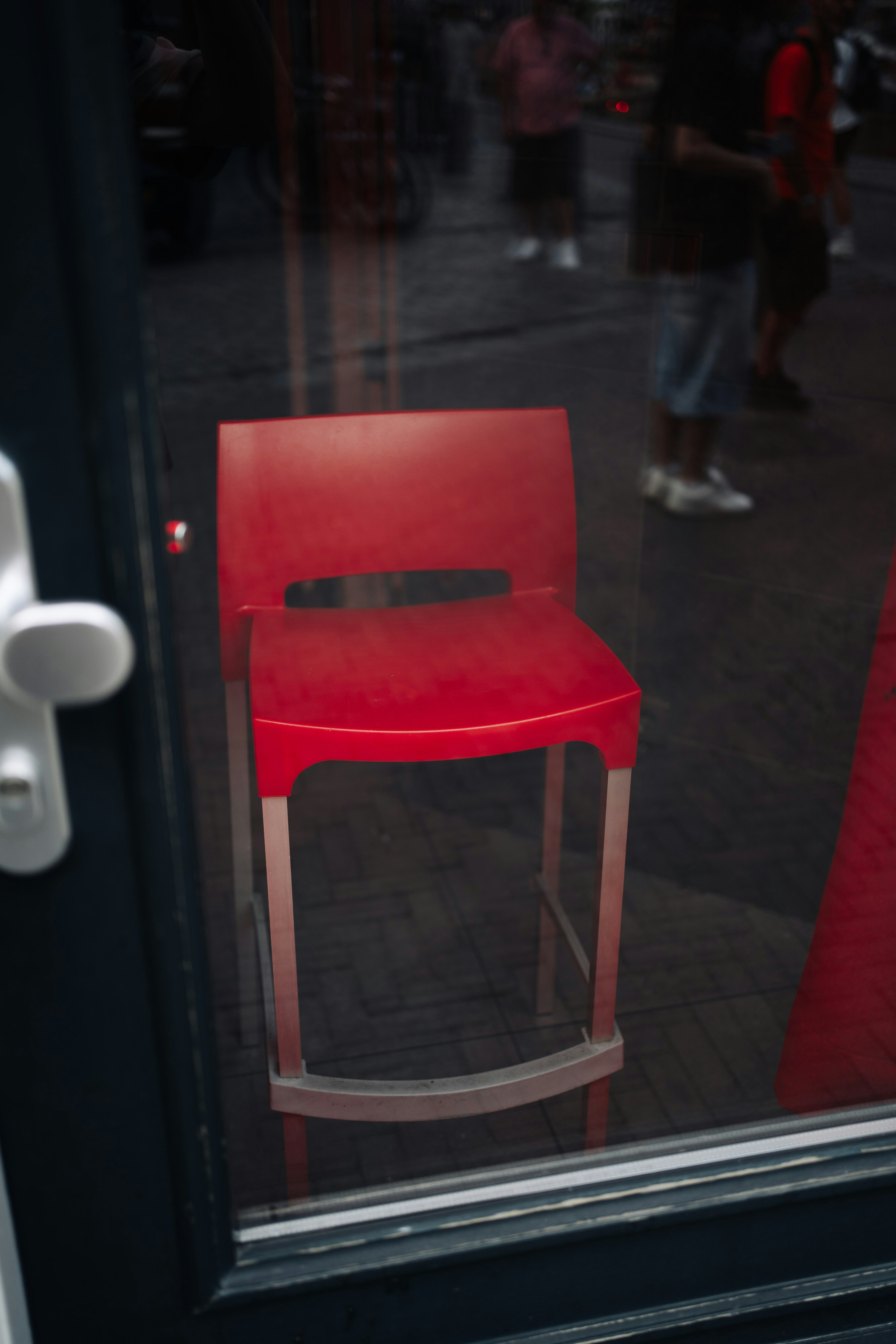 Red Chair Behind Glass: Urban Reflections and a Bold Accent