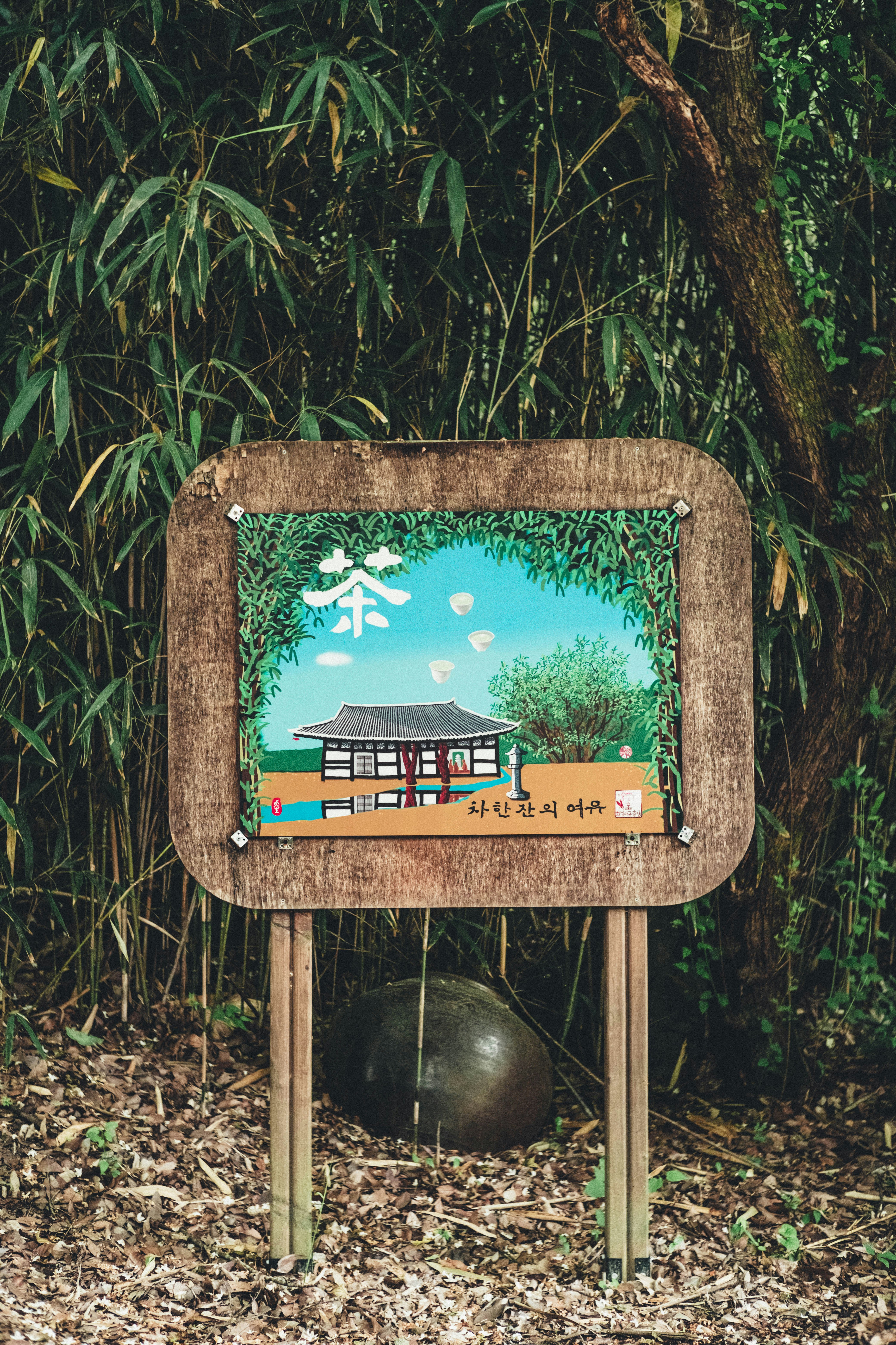 Bamboo-Framed Temple Illustration on a Weathered Sign