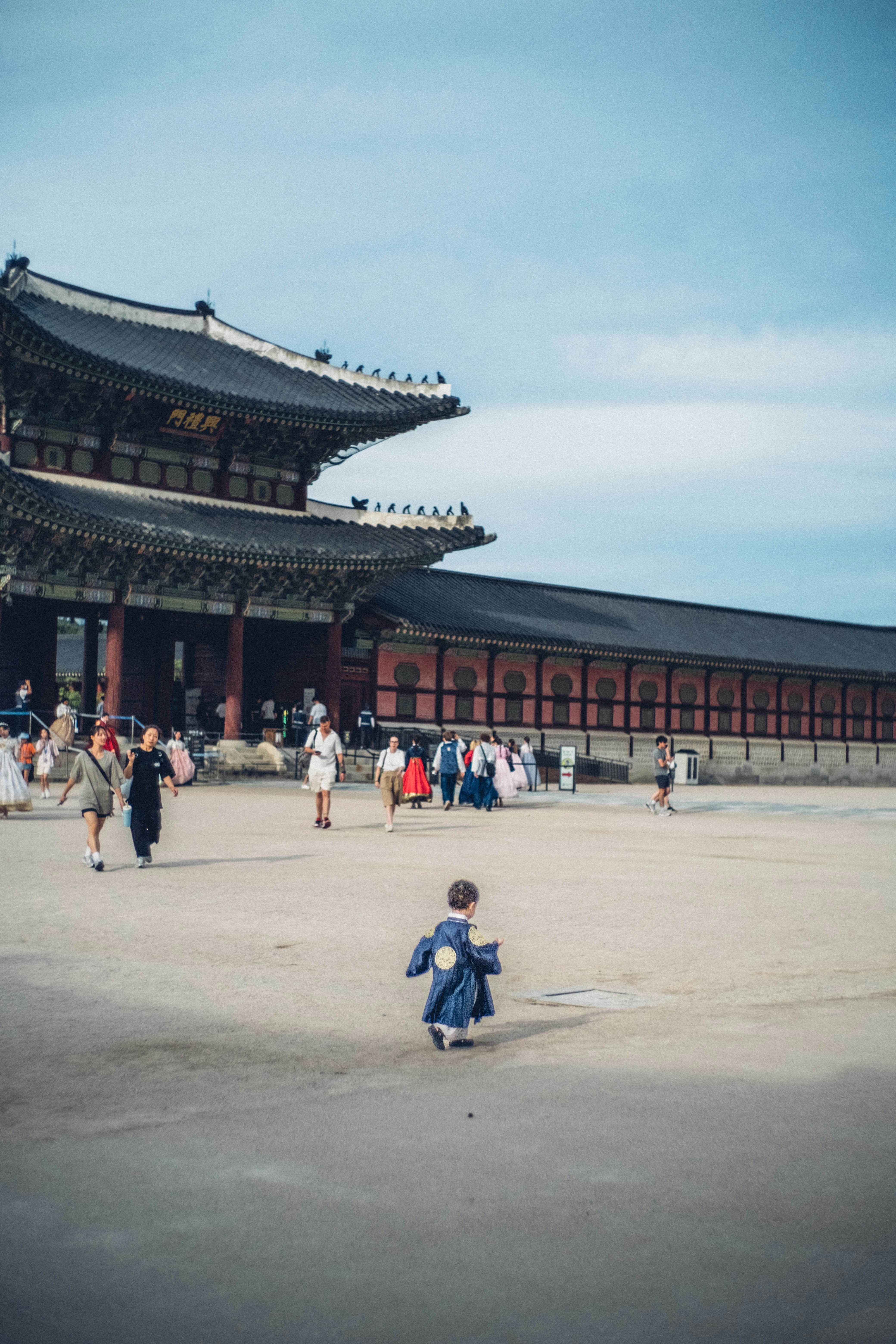 Blue-Robed Run Across a Historic Korean Palace Courtyard