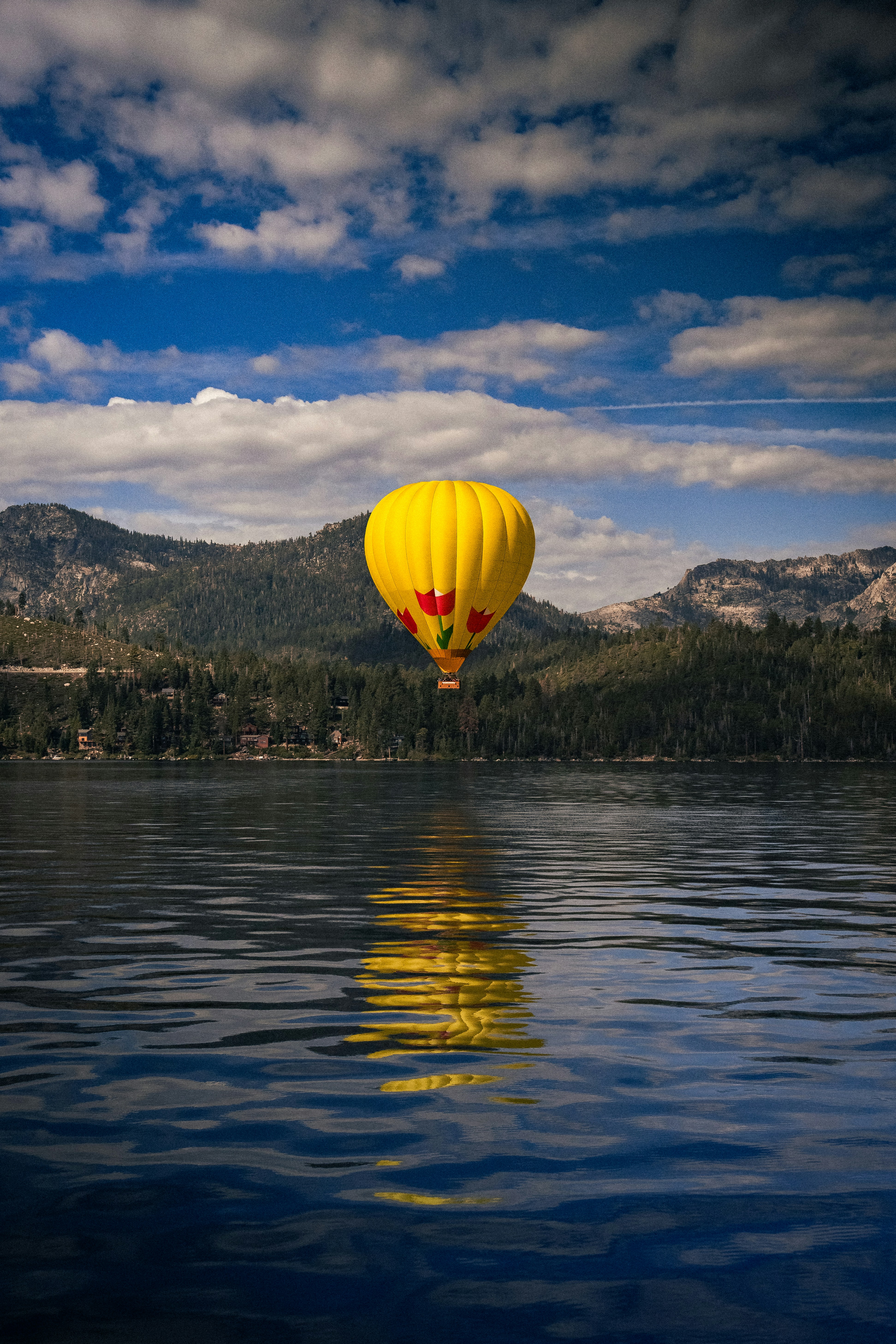 Golden Ascent: A Balloon's Journey Over Tranquil Waters