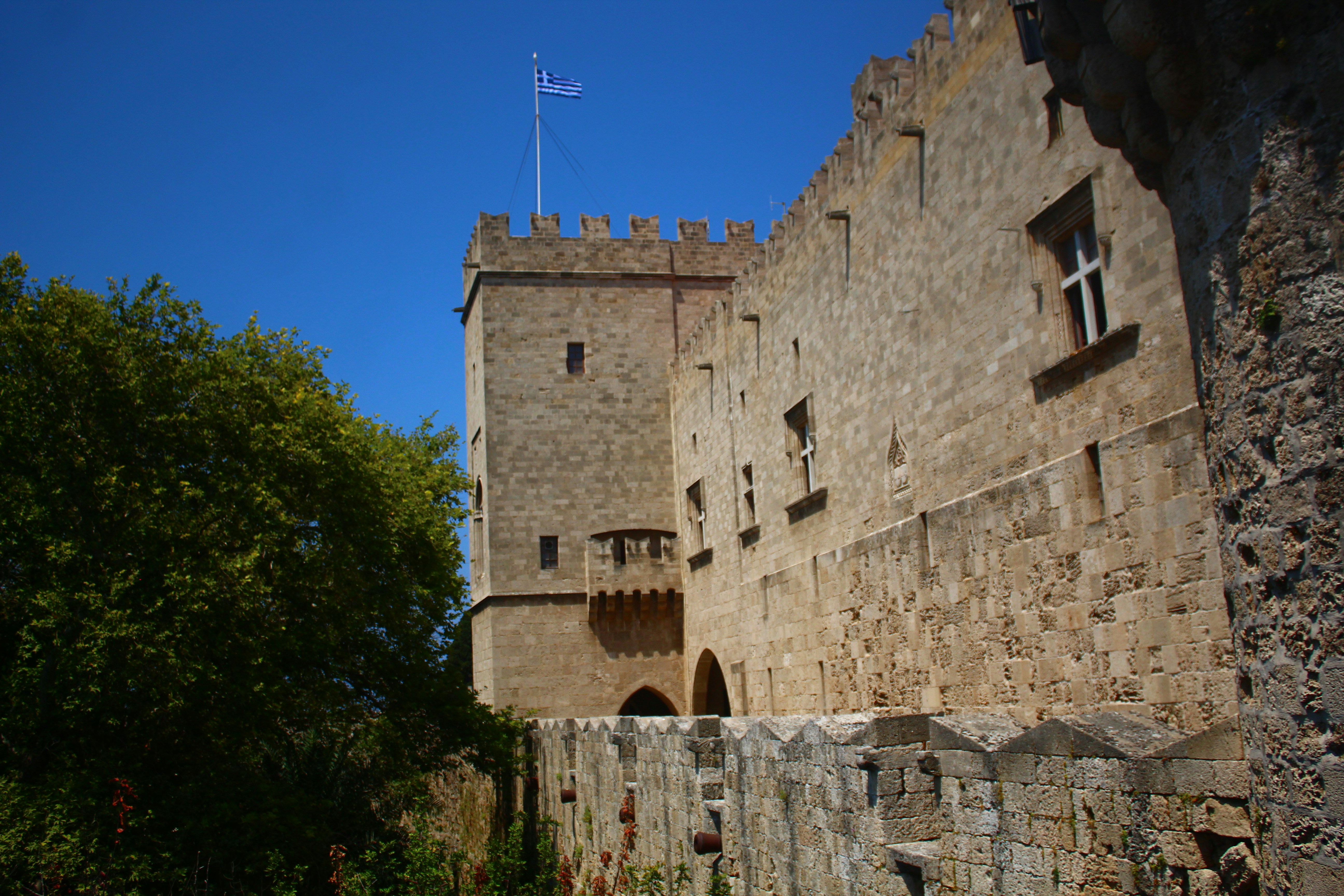 Ancient stone castle with a flag under blue sky